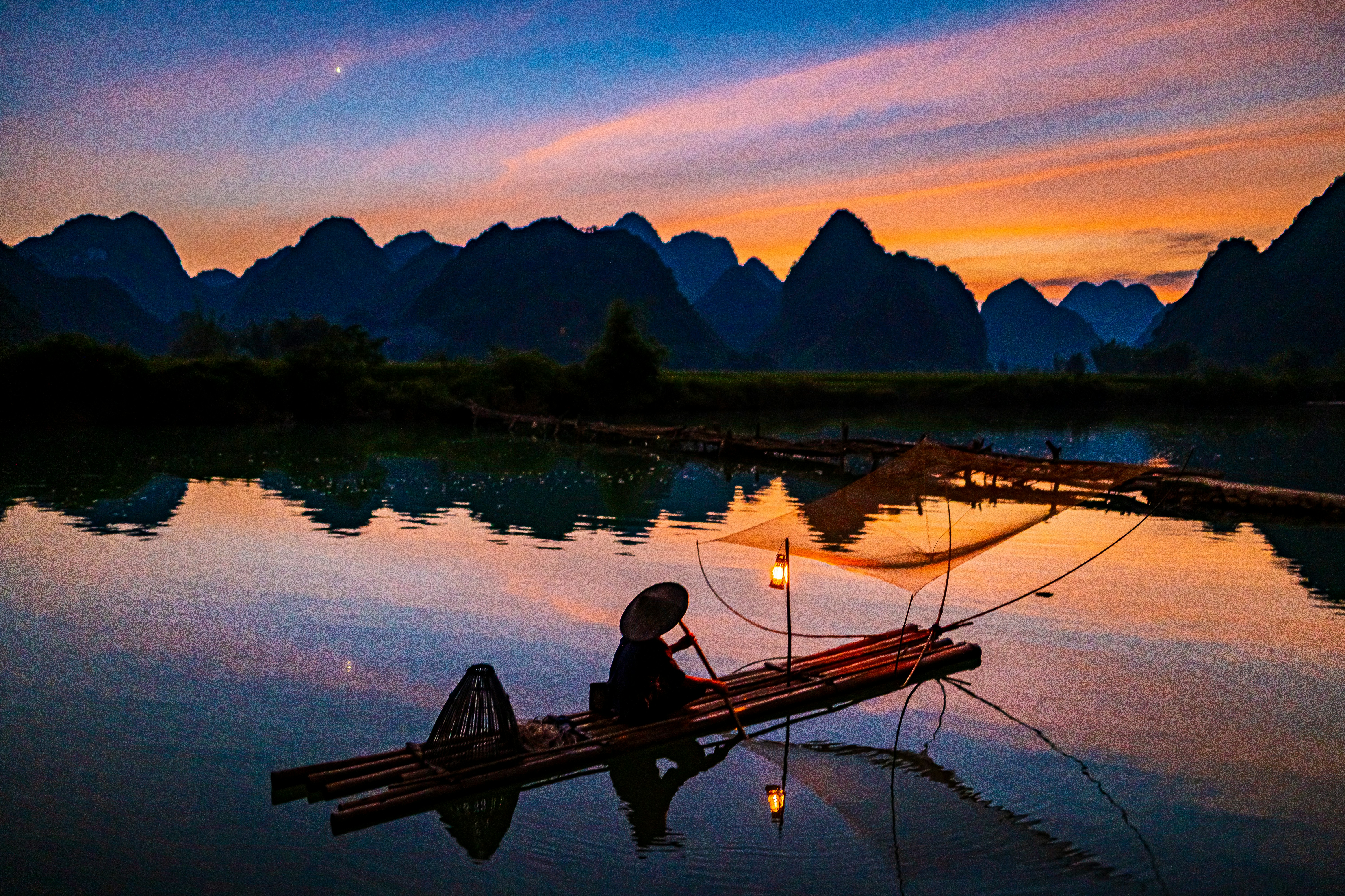 Lantern on the River: A Fisherman’s Quiet Vigil at Dusk