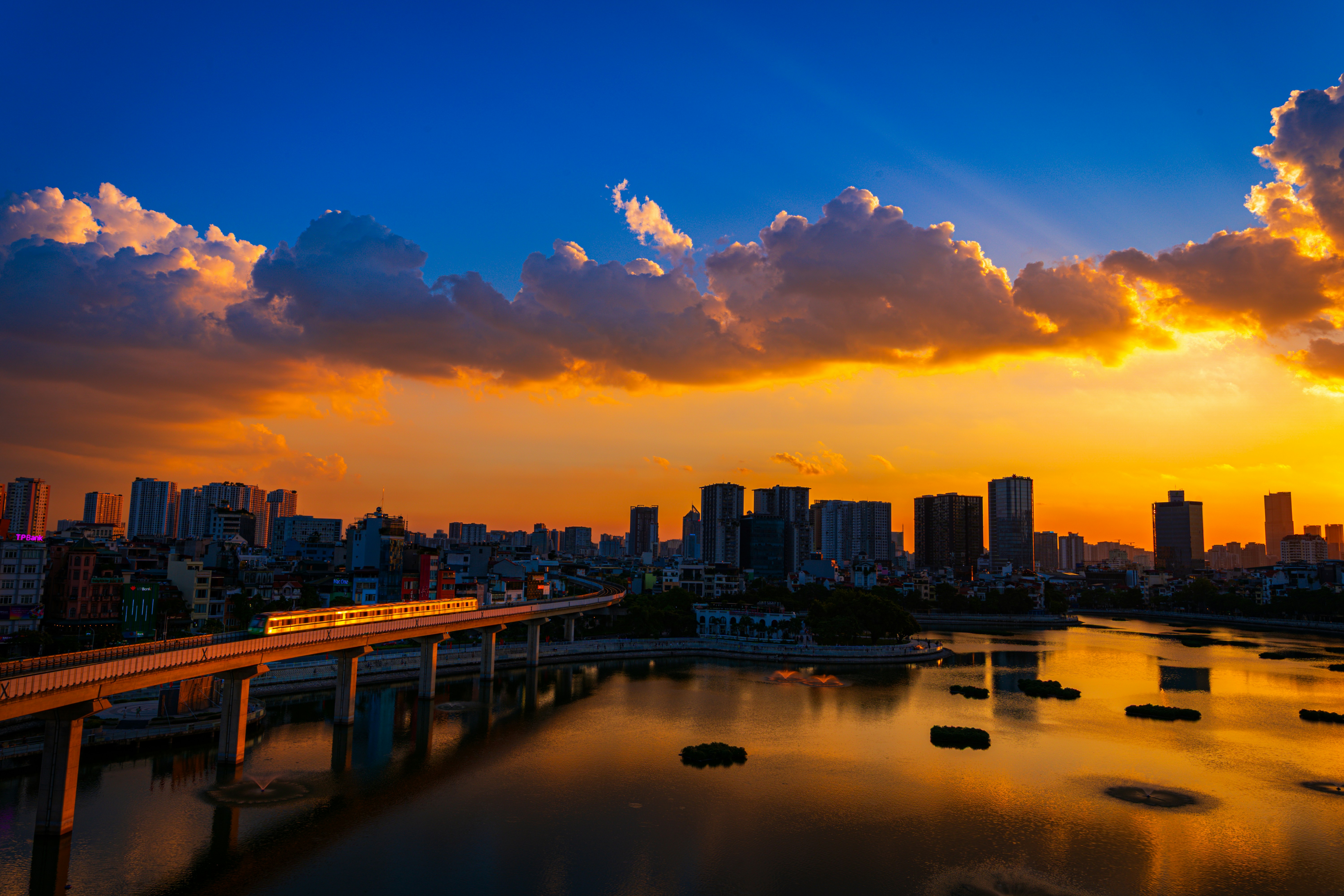 Golden Hour Over the River: City Silhouettes Beneath a Luminous Sky