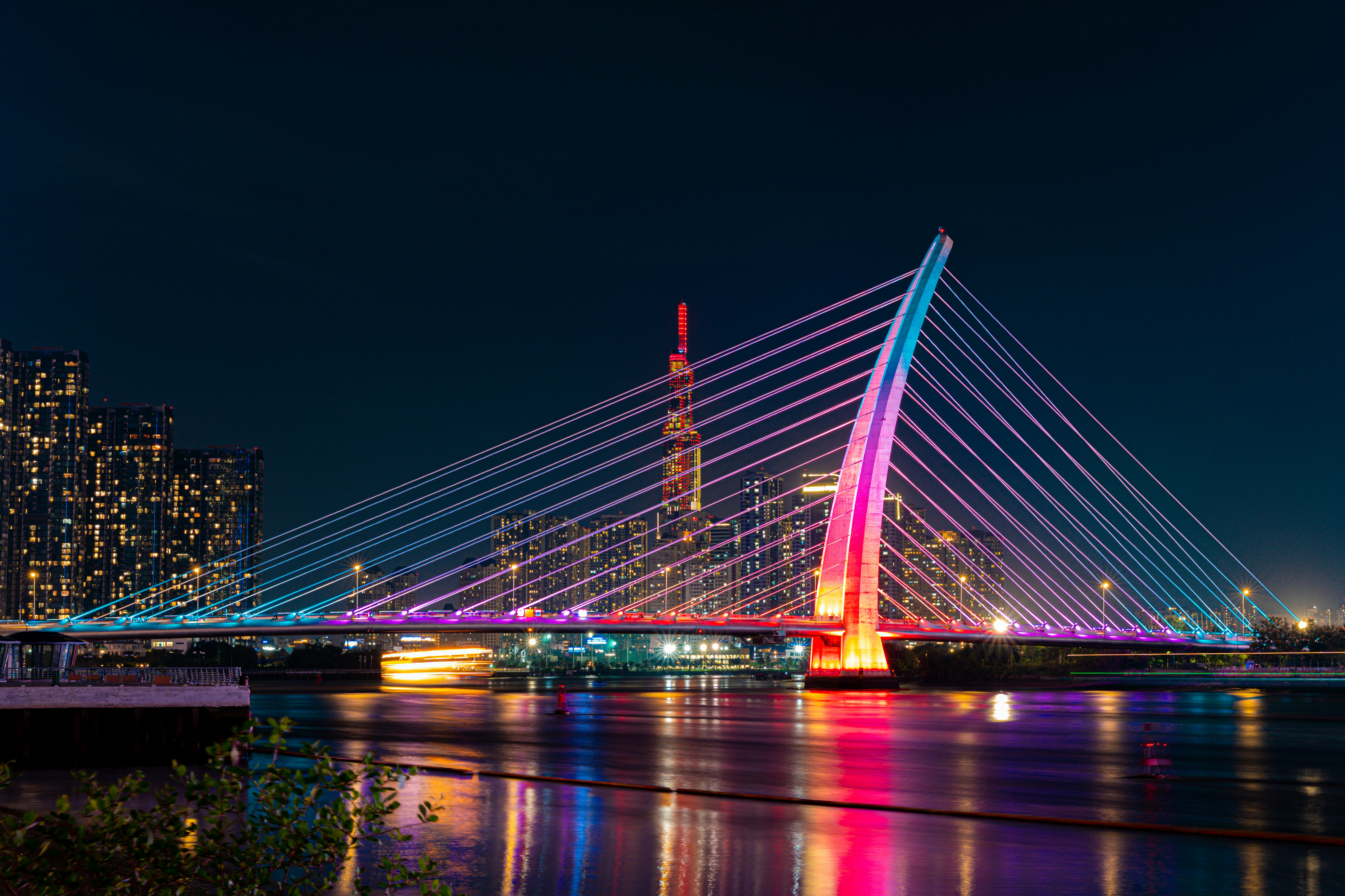 Neon Arc: A Night River Bridge Bathed in Chromatic Light