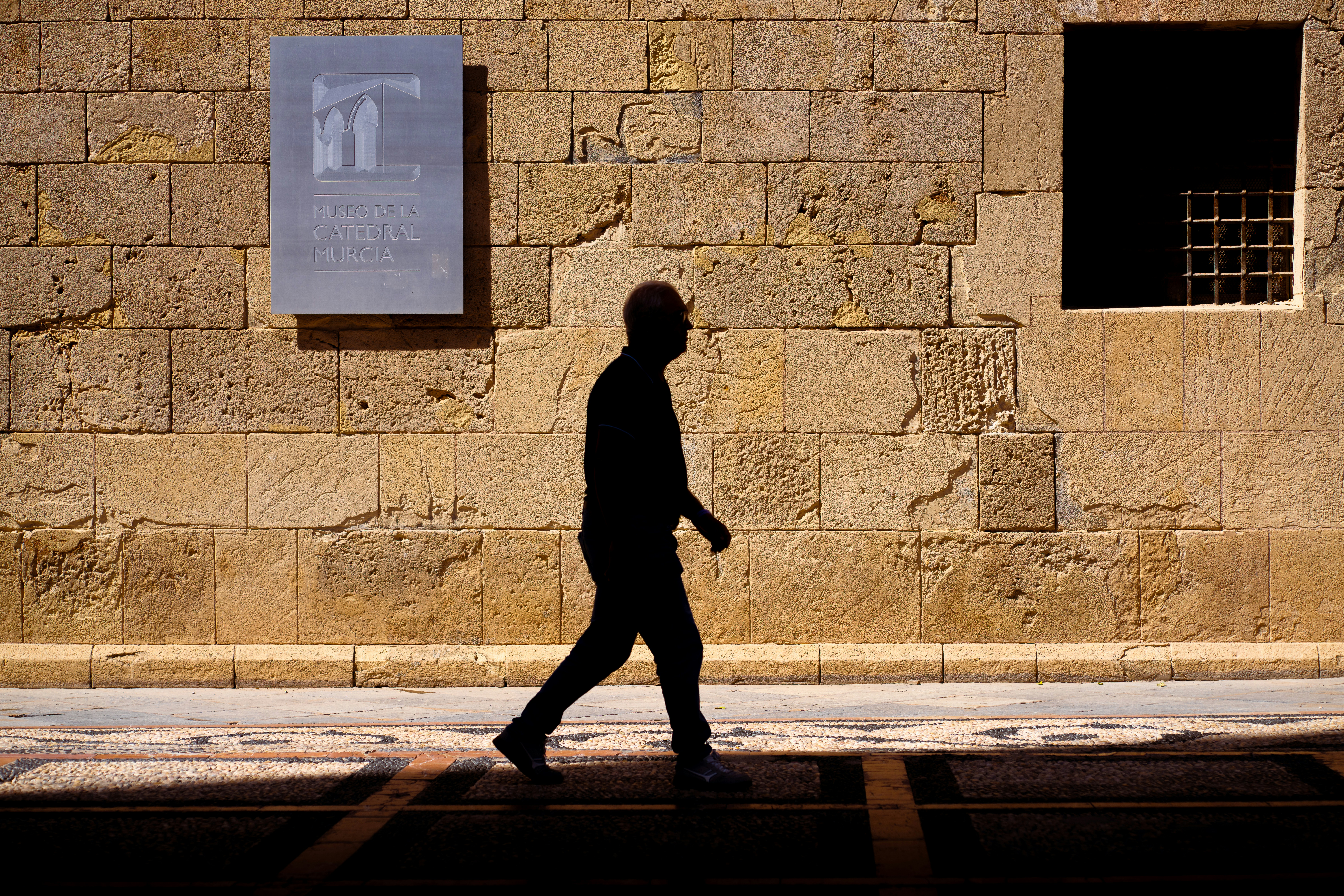 Solitary stride along sunlit stone