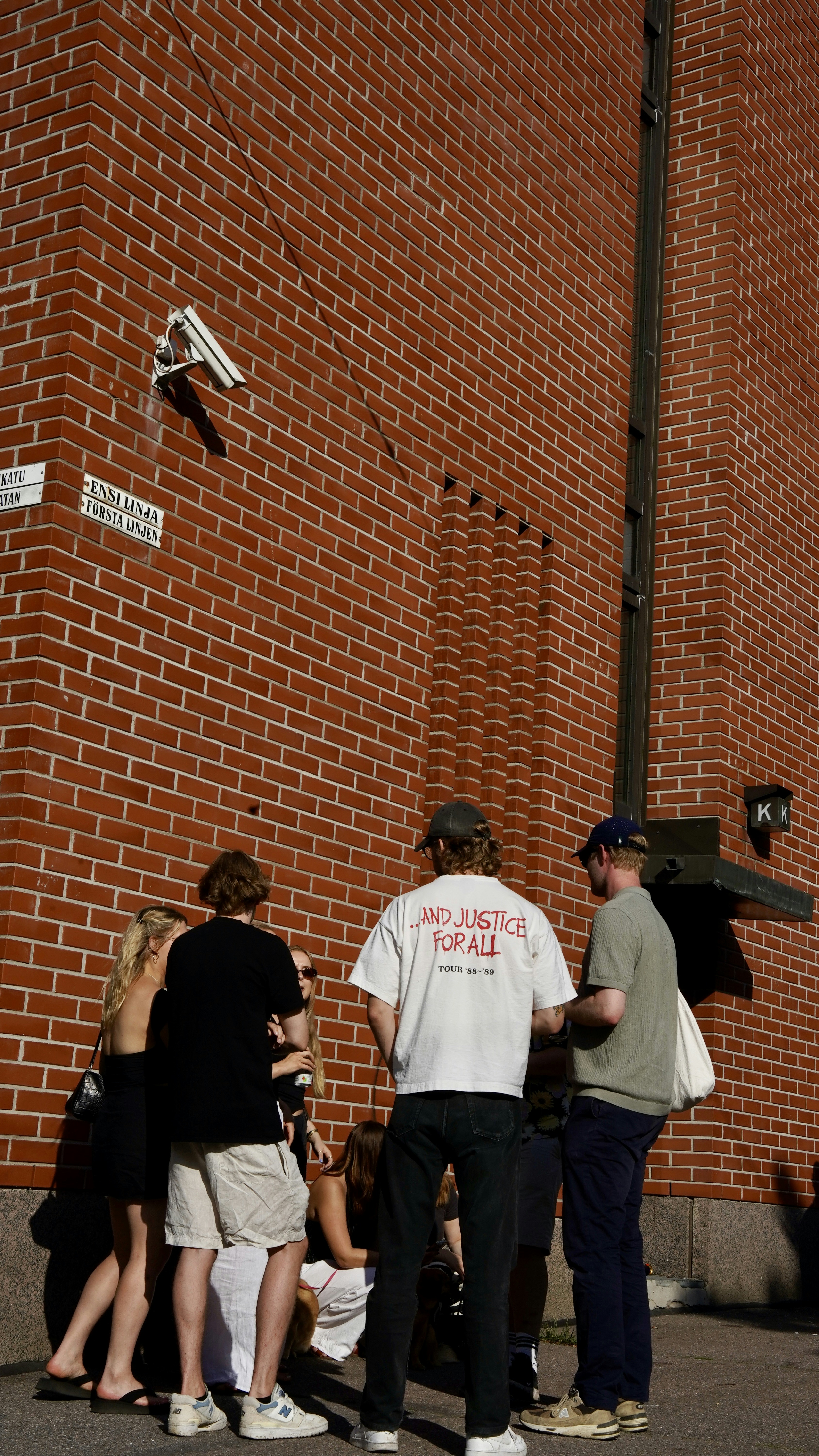 Gathered Voices Outside a Brick Facade