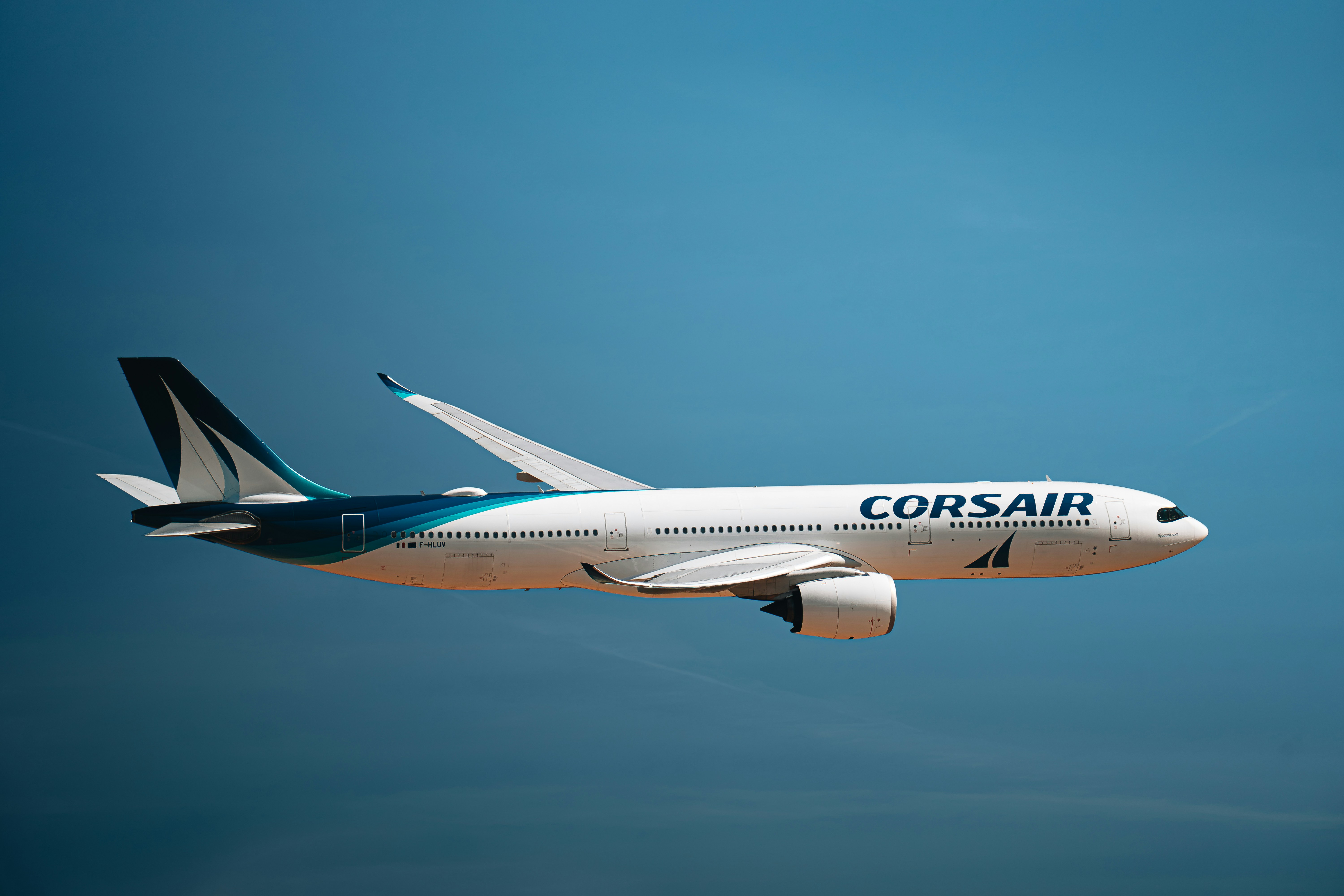 Corsair in the Clear: A sleek airliner glides over a vivid blue sky
