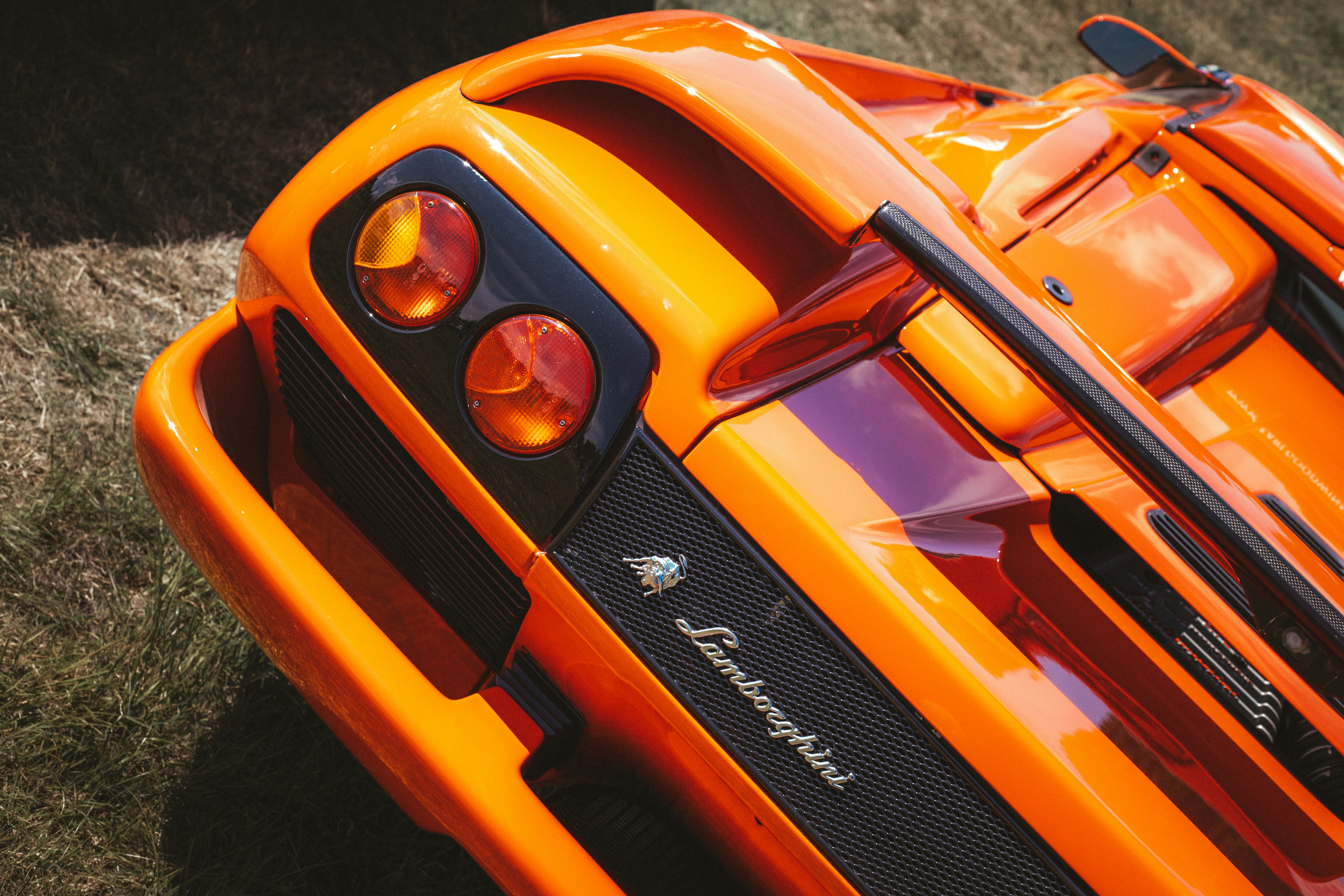 Orange Supercar Hood: A Close-Up of Aerodynamic Curves and Emblem