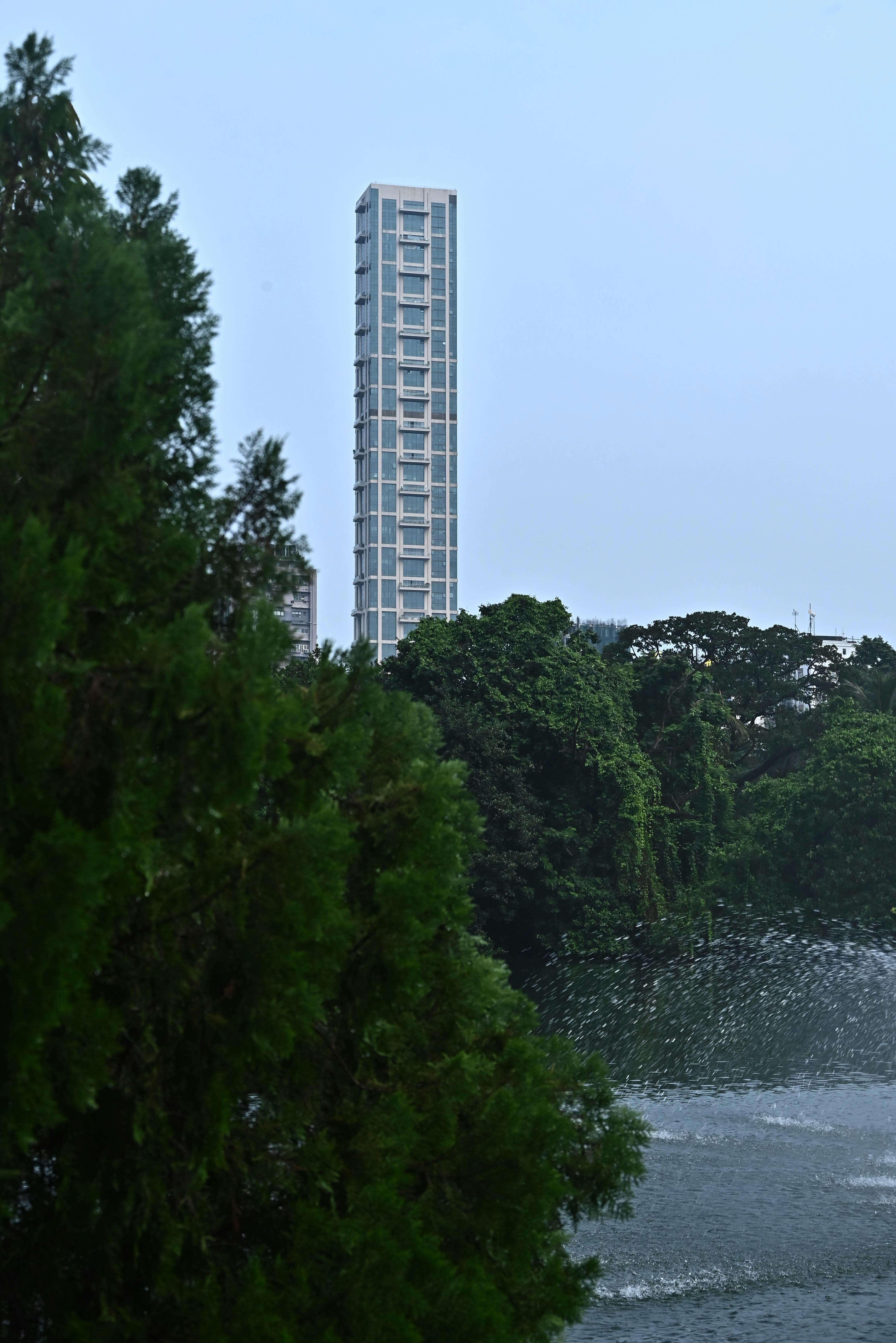 Tower Rising Over Green Verge by the Water