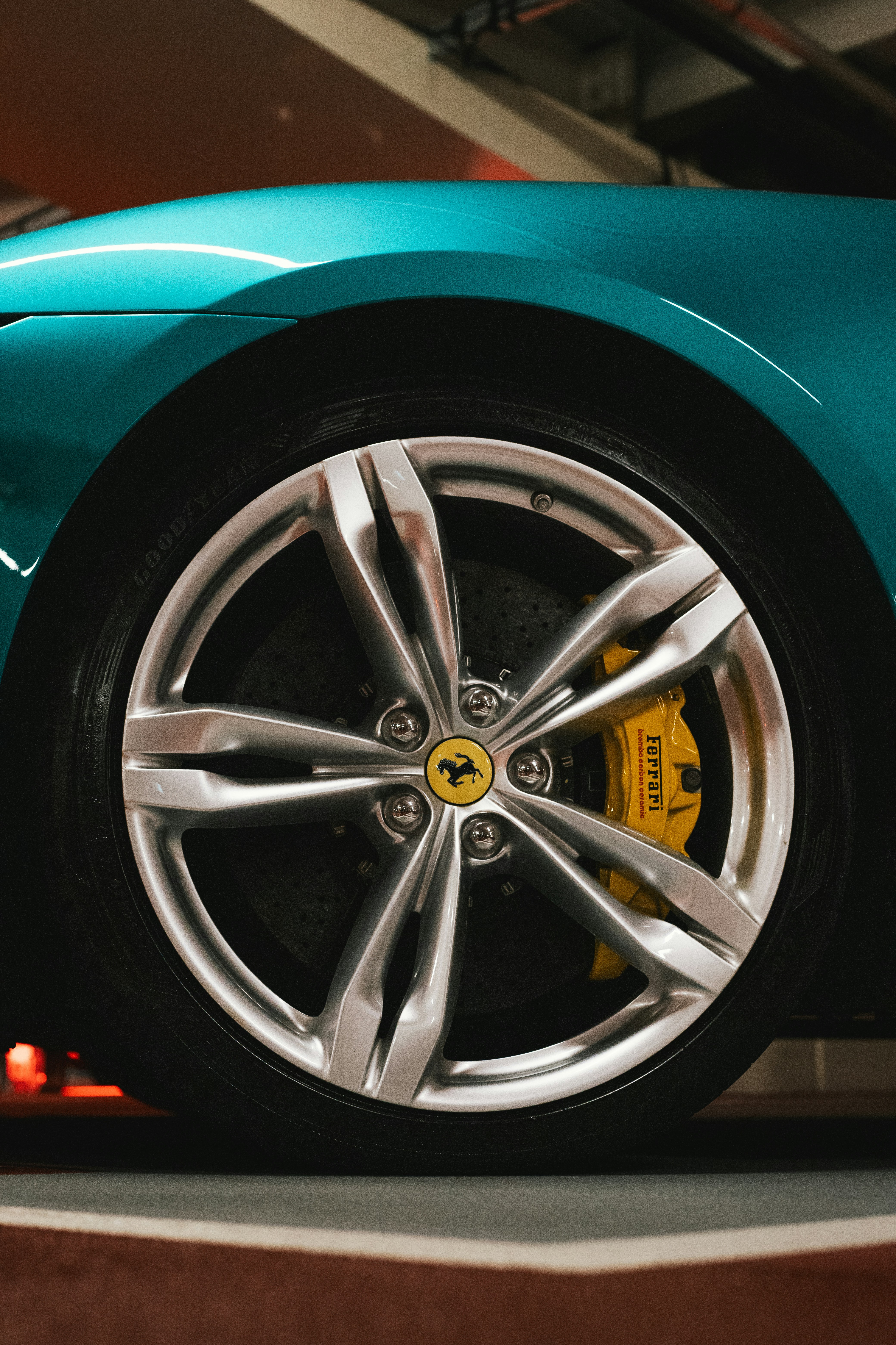  teal Ferrari wheel: chrome spokes and yellow caliper peeking through