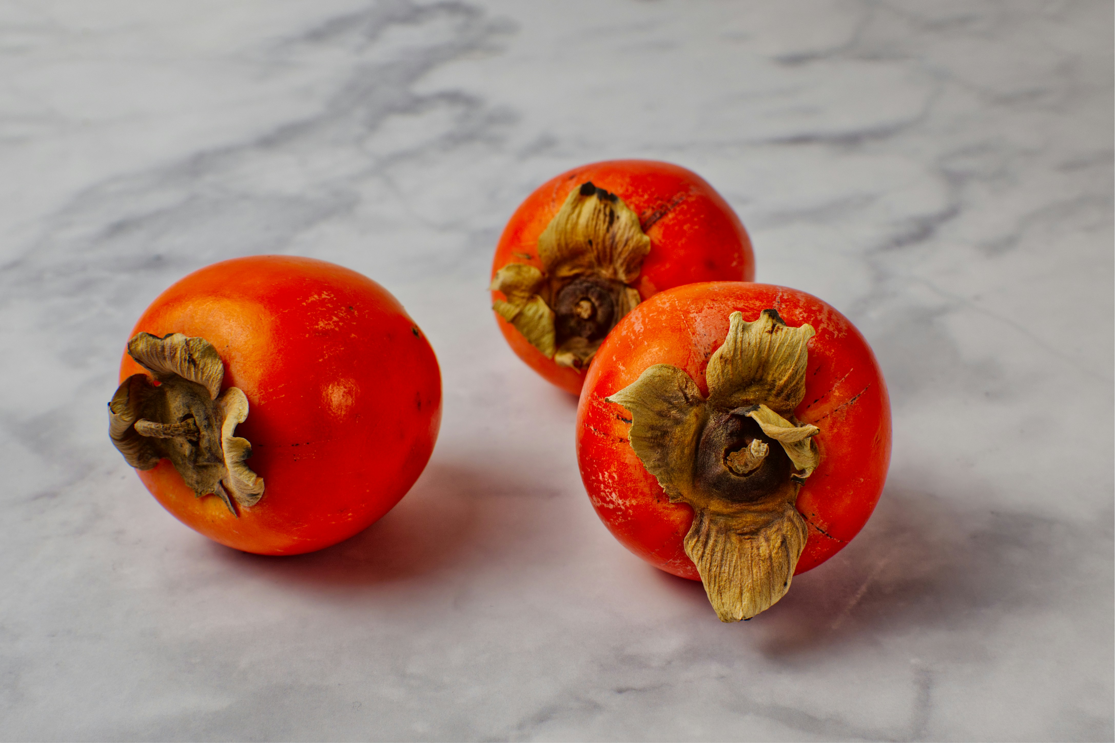 Three Persimmons on Cool Marble