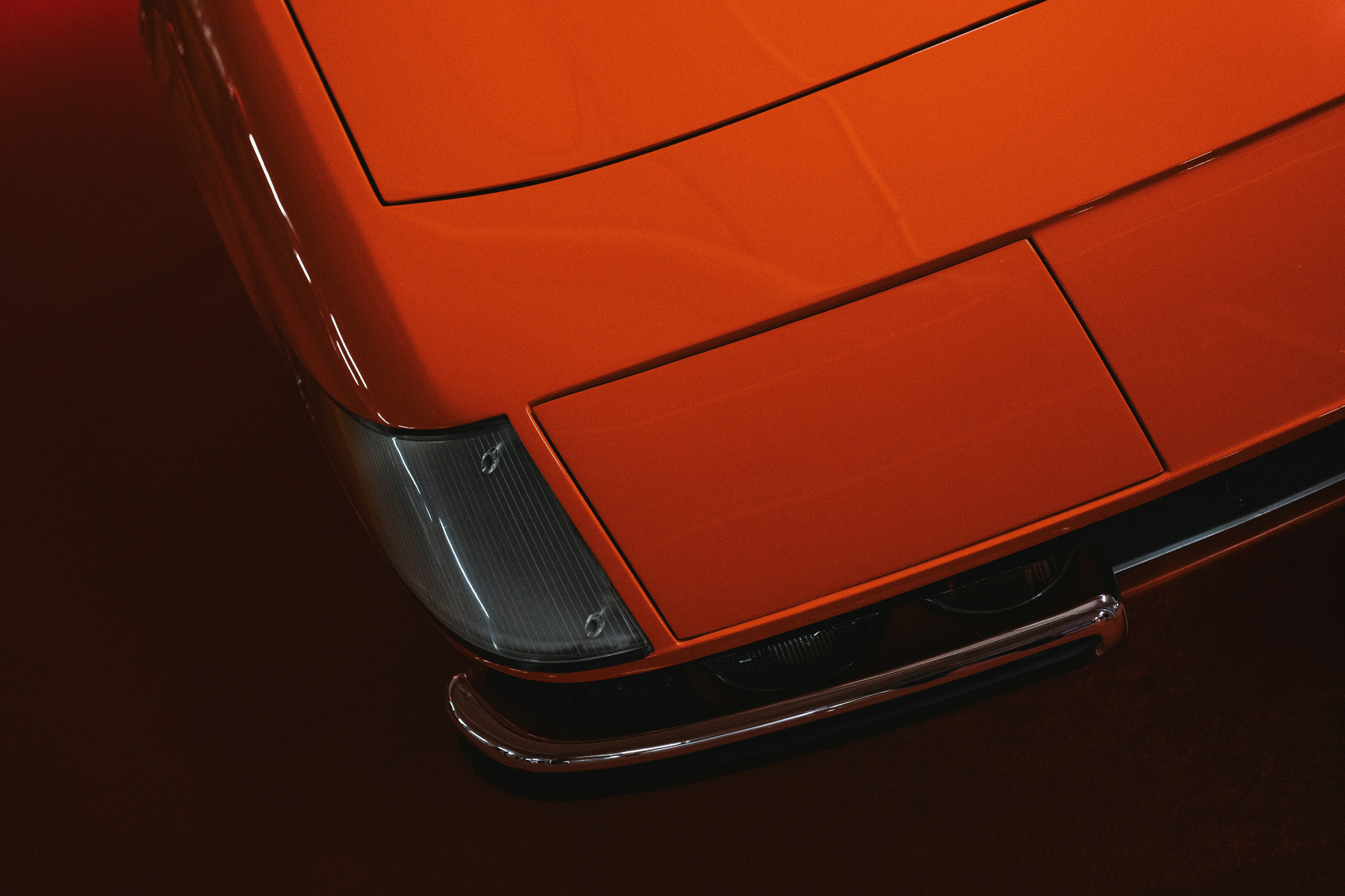 Orange Car Hood: A Quiet Glimpse of Curves and Chrome