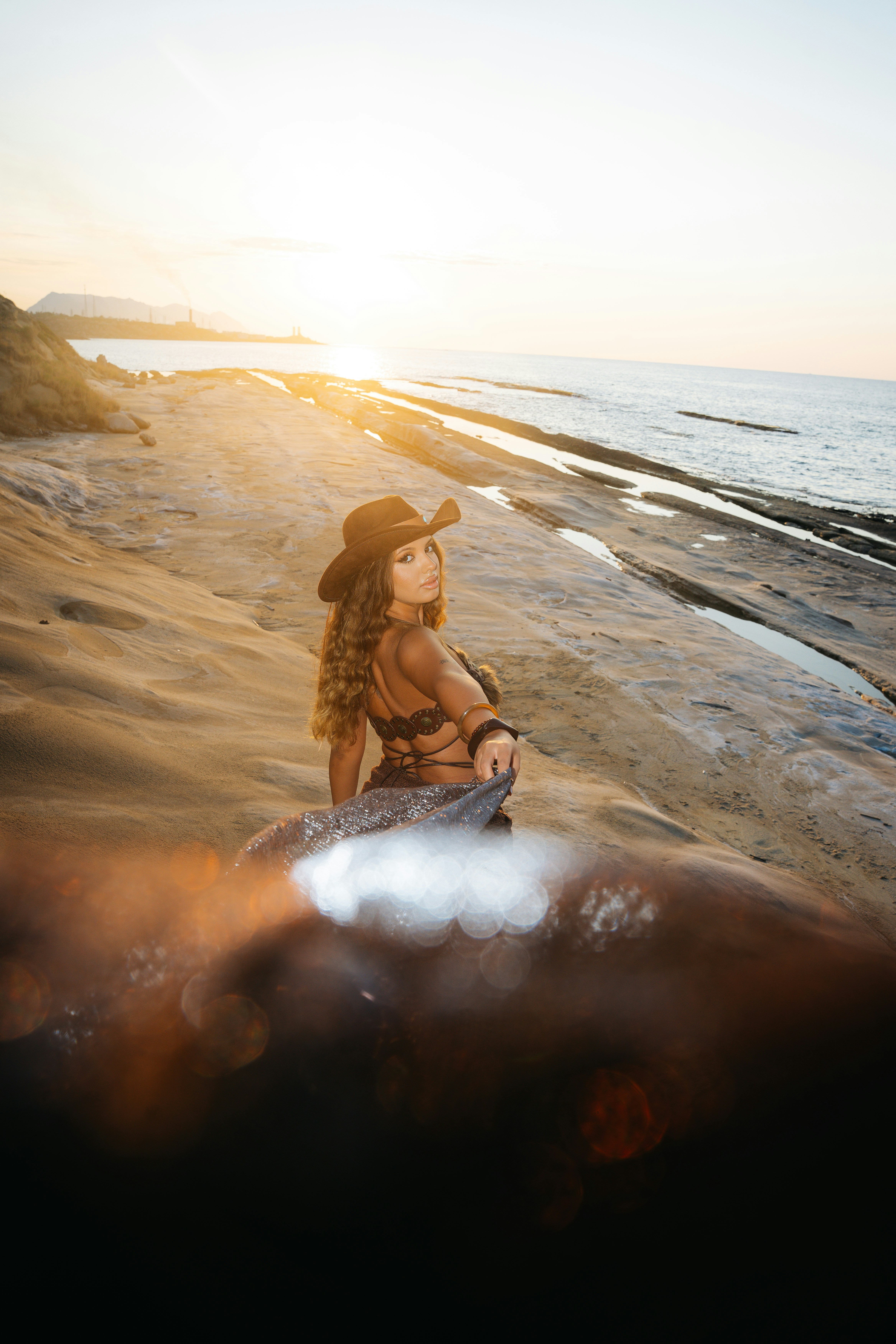 Sunlit Serenade: Beachgoer in a Wide Hat at Golden Hour
