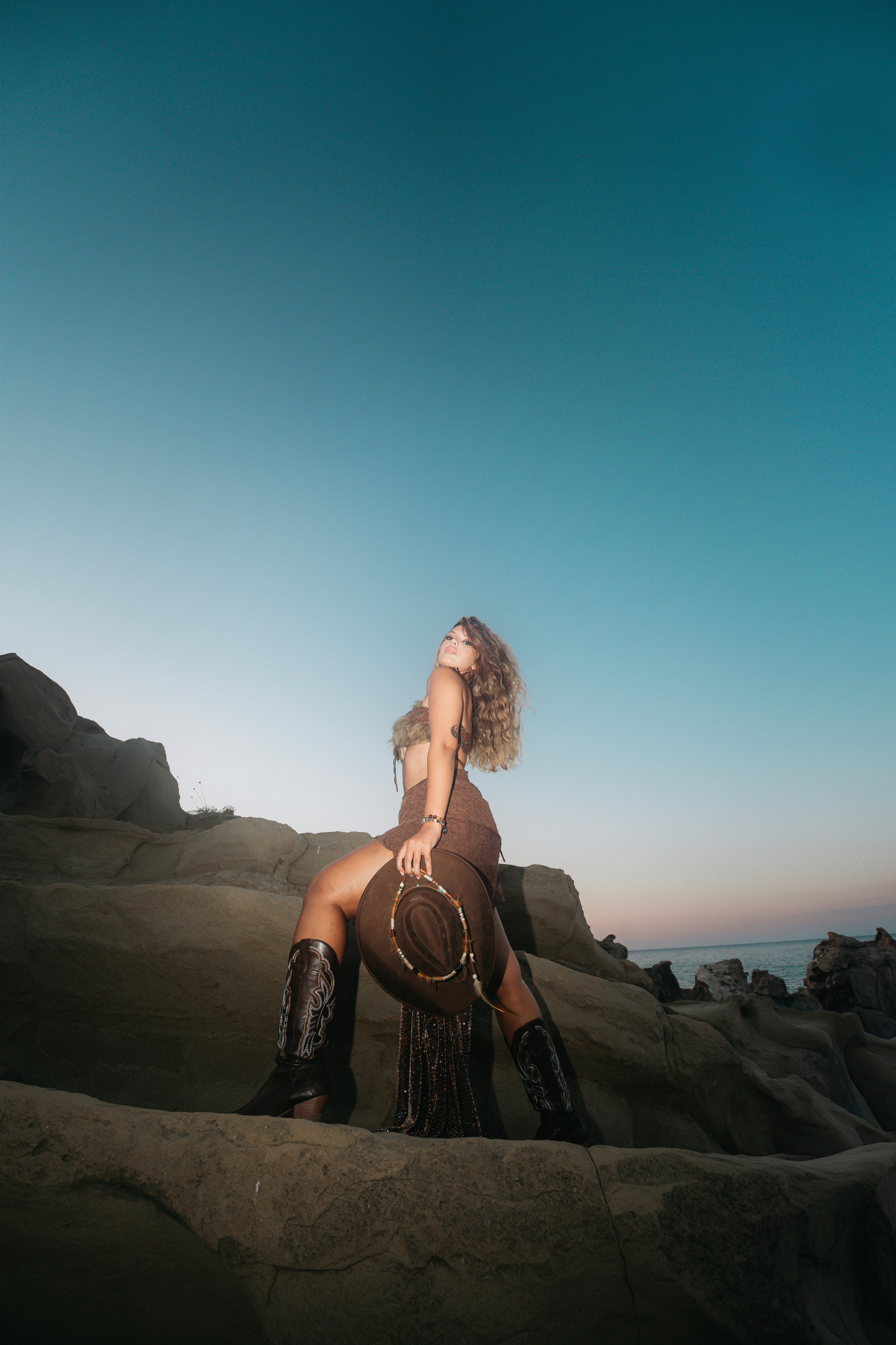 Sunlit Silhouette: A Heroic Pose on Rugged Shoreline