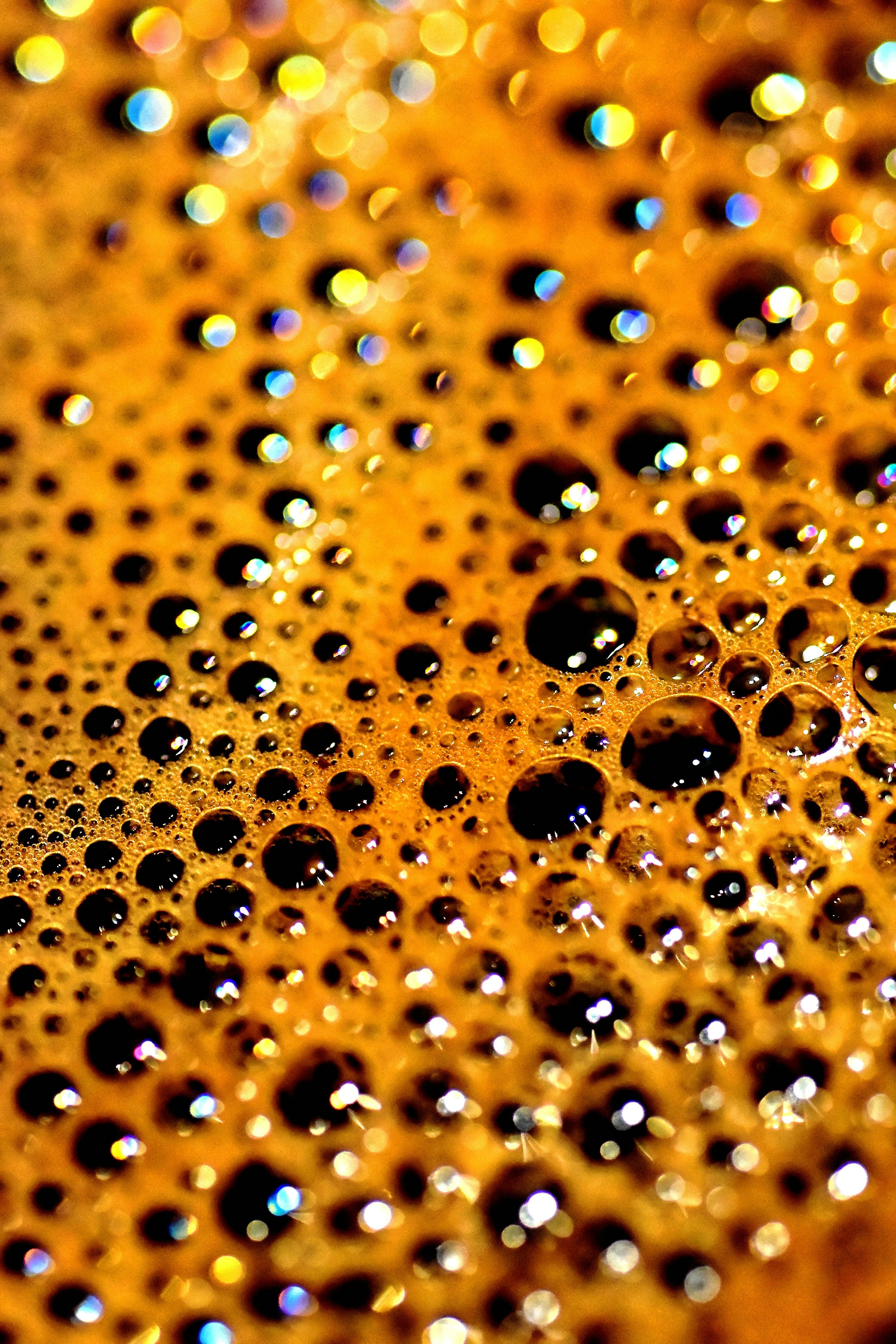 Close-up of Fizzing Caramel Bubbles: Golden Foaming Texture