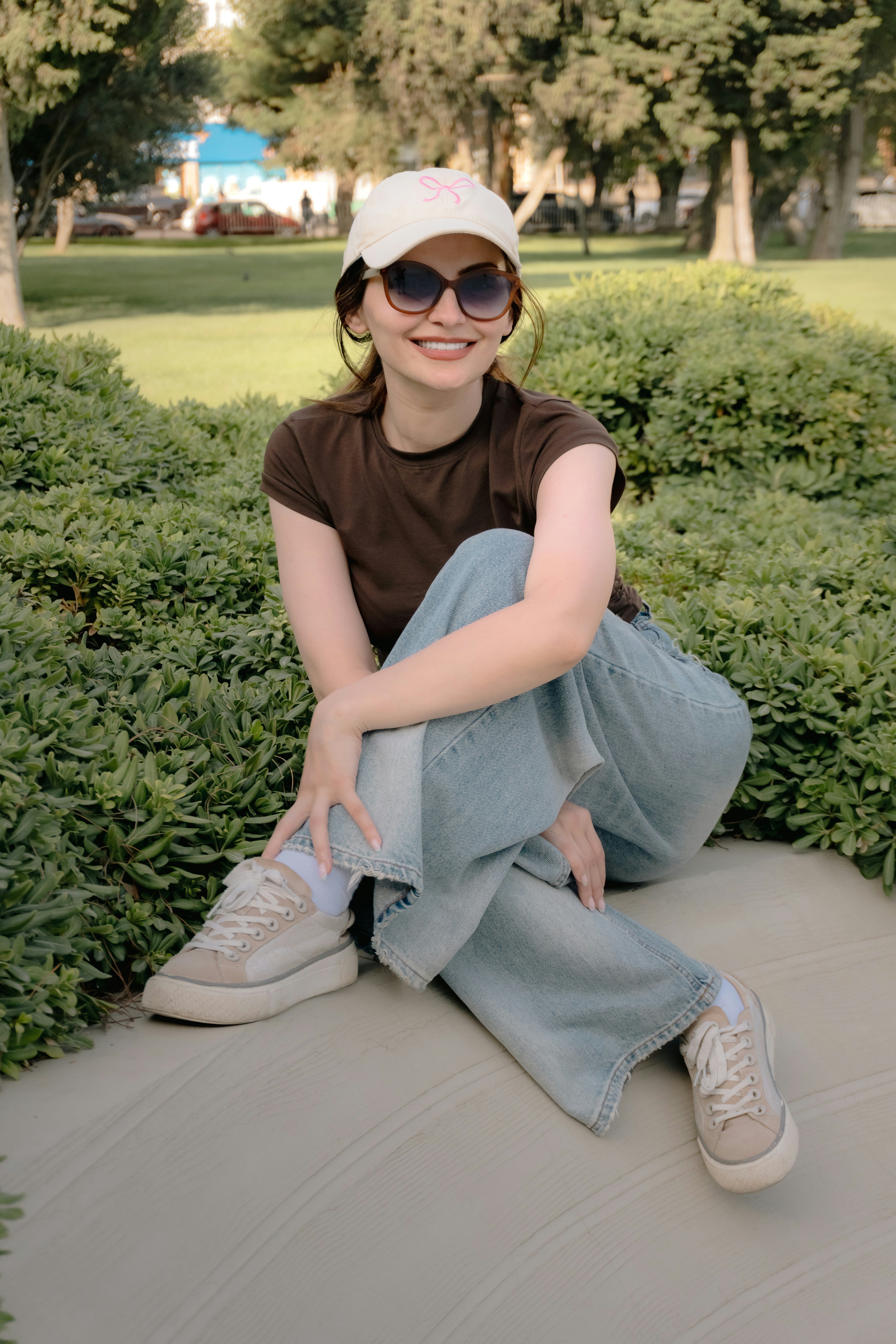 Smiling wanderer in a sunlit park with sneakers and cap