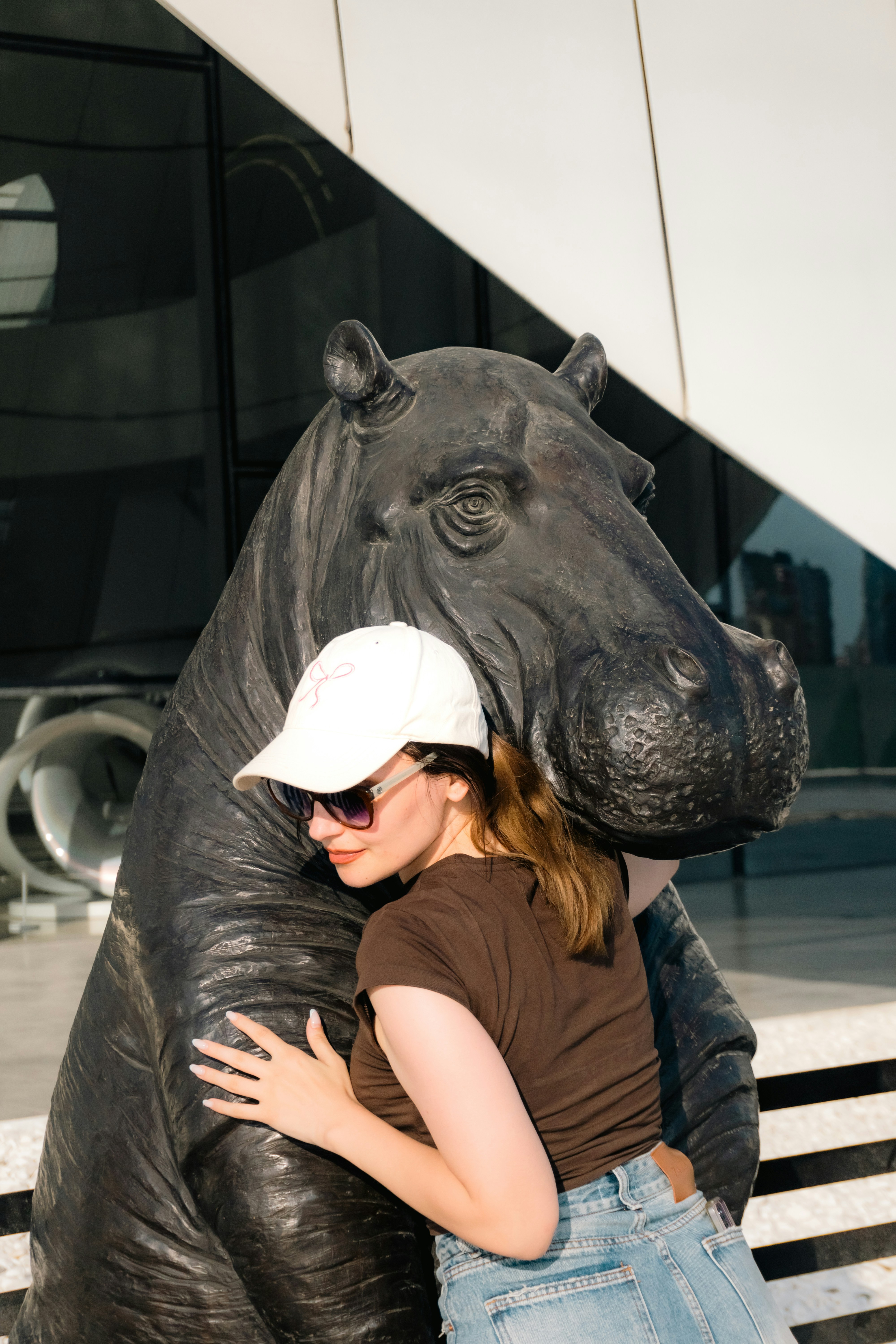 Hugging a Giant: a playful moment with a horse sculpture in modern architecture