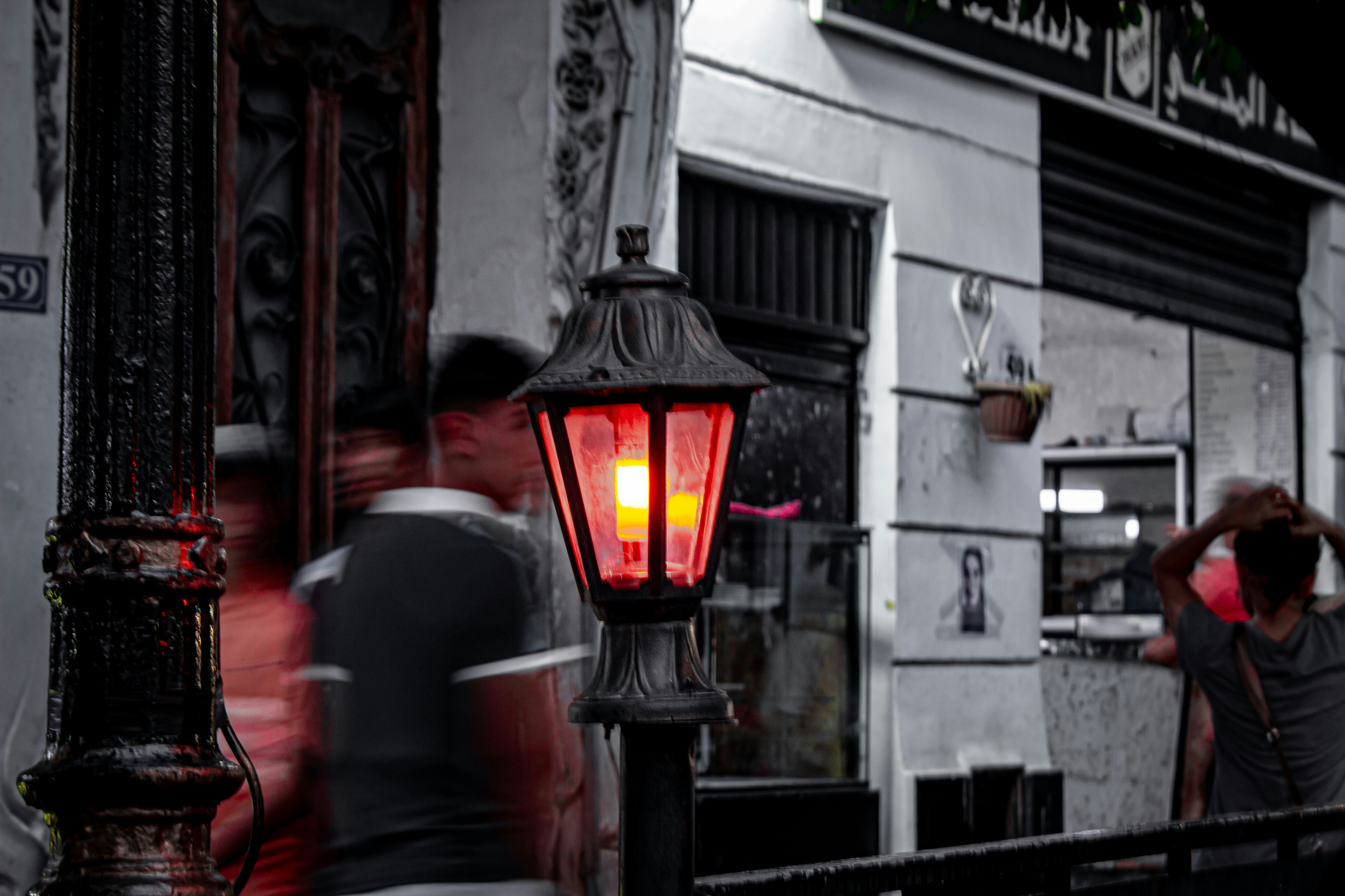 Red Lantern Amid Blurred Movement in a Narrow Street