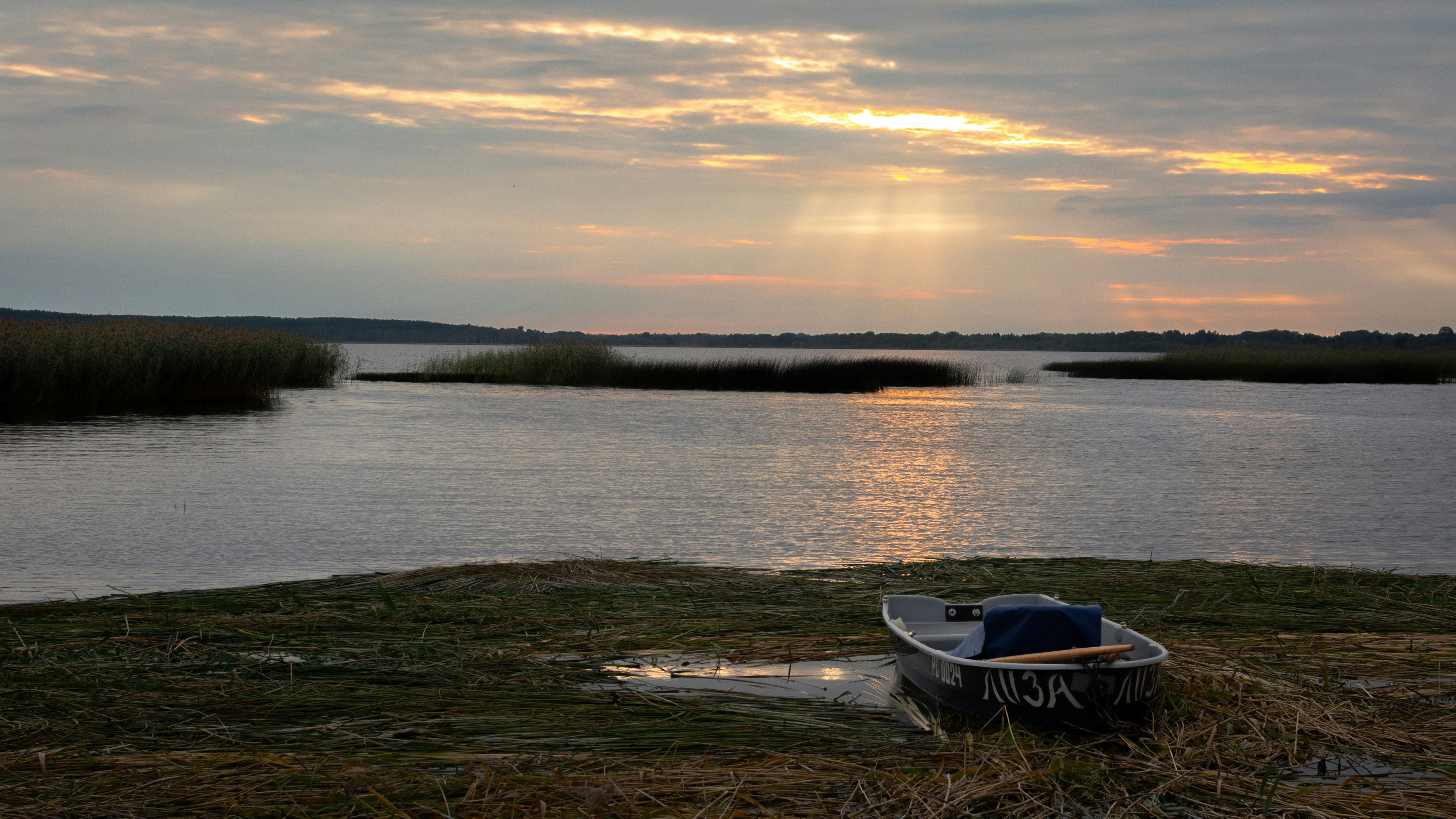 Sunset Over Quiet Wetlands: A Dusk Boat Rest on Mudflats