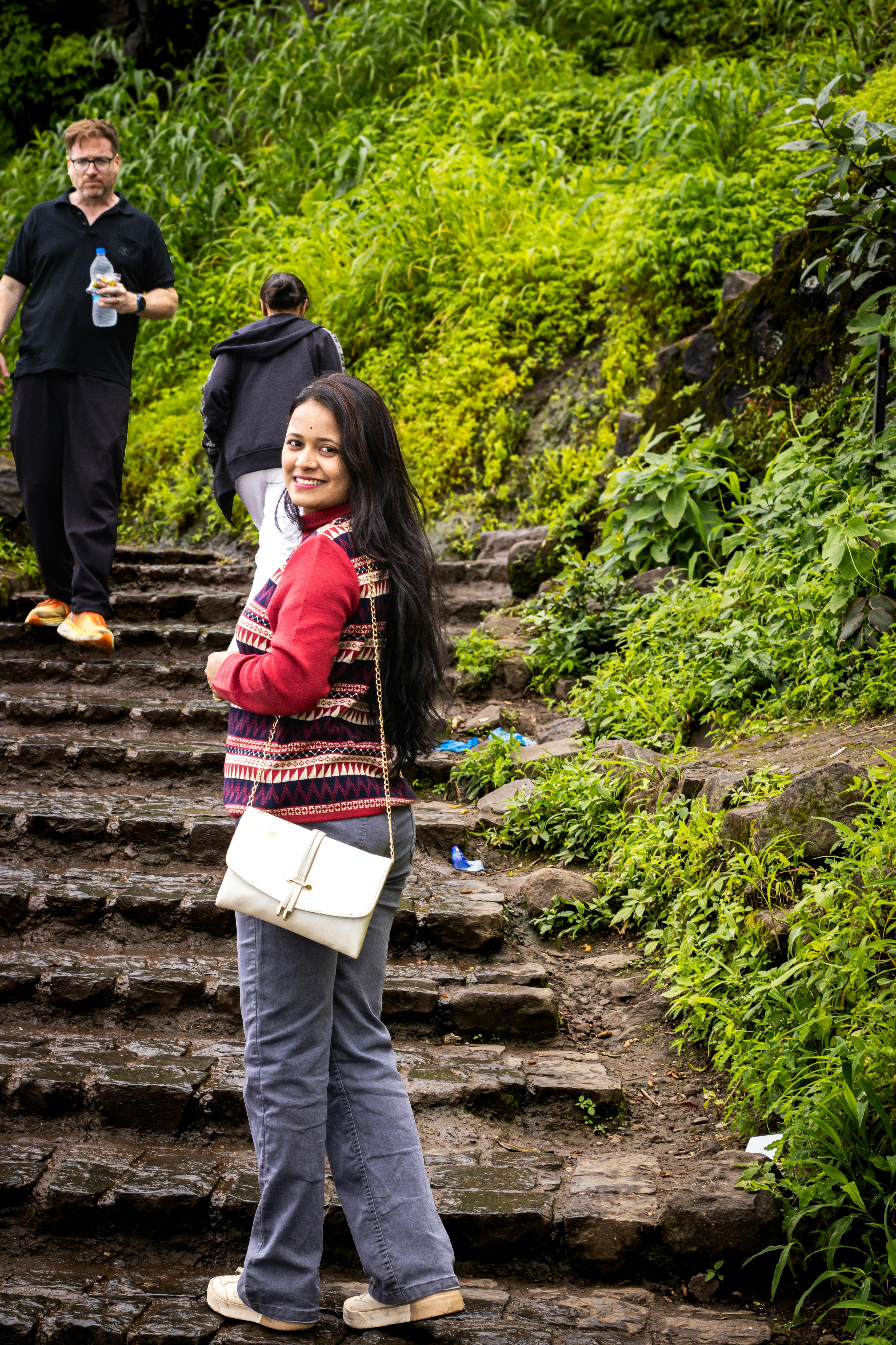 Smiling wanderer on a stone stairway amidst lush greenery