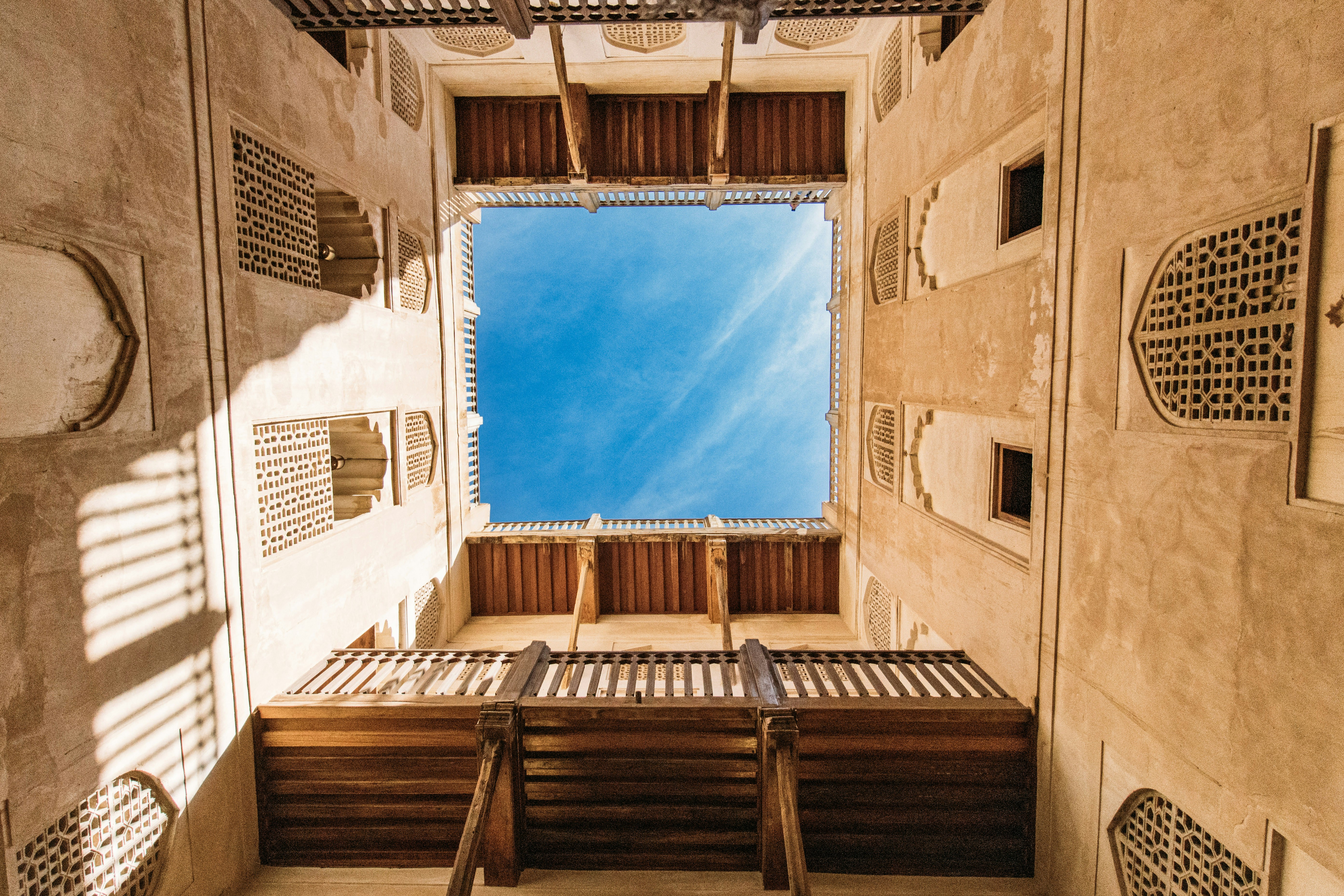 Skyward Atrium: Open Roof Framed by Moorish Facades