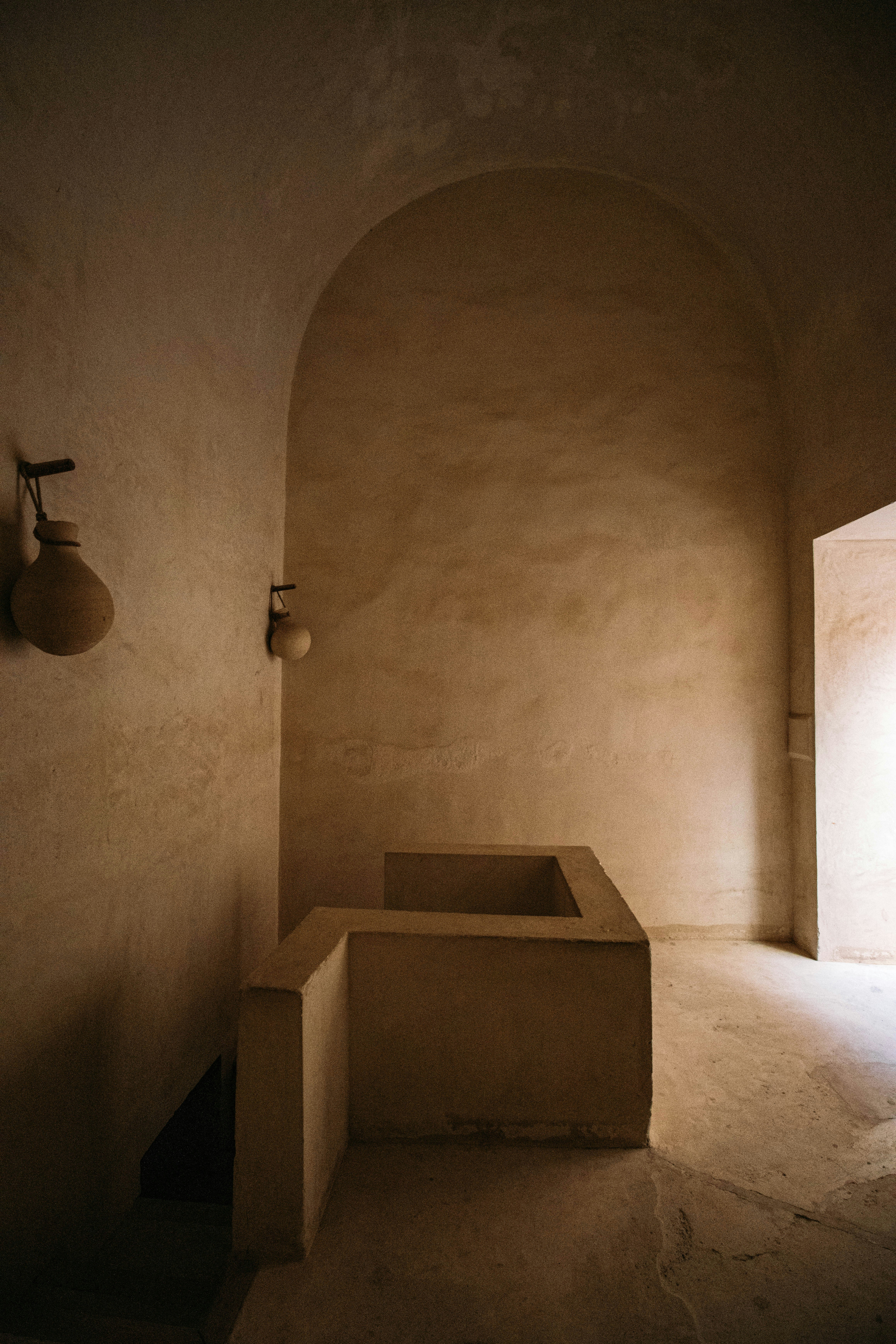 Muted Archway Corridor with Corner Sink and Soft Lighting