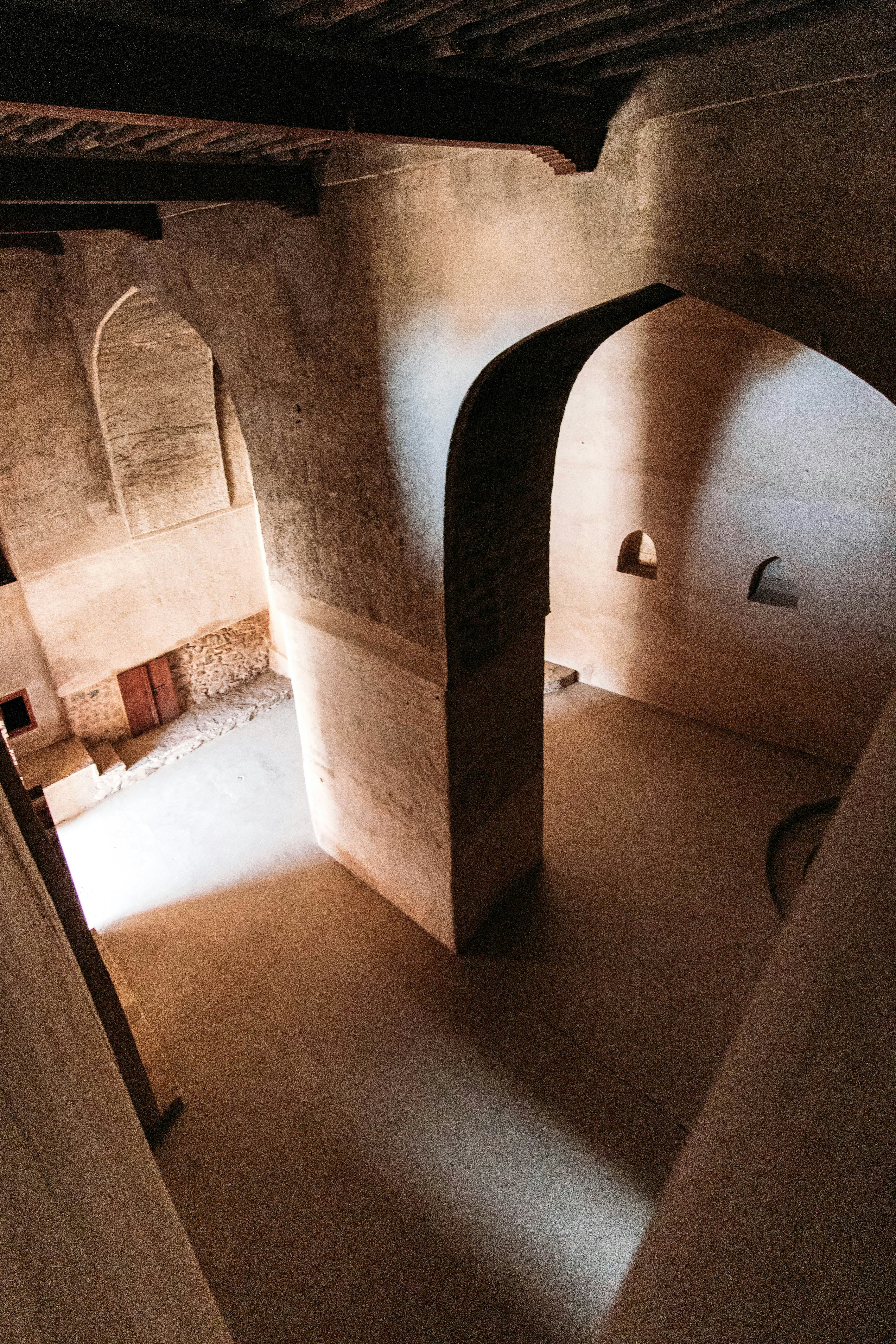 Light carved through ancient arches: a hushed ascent inside a fortress hall