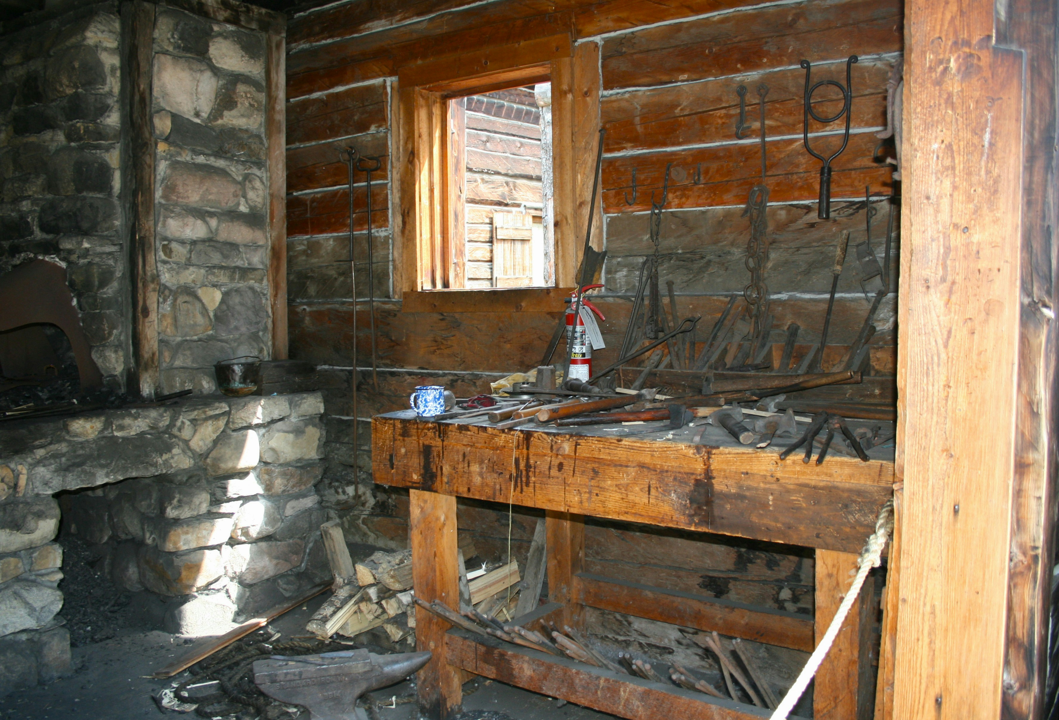 Hearthside Workshop: Weathered Tools and Wooden Workbench in a Smoke-wcarved Corner