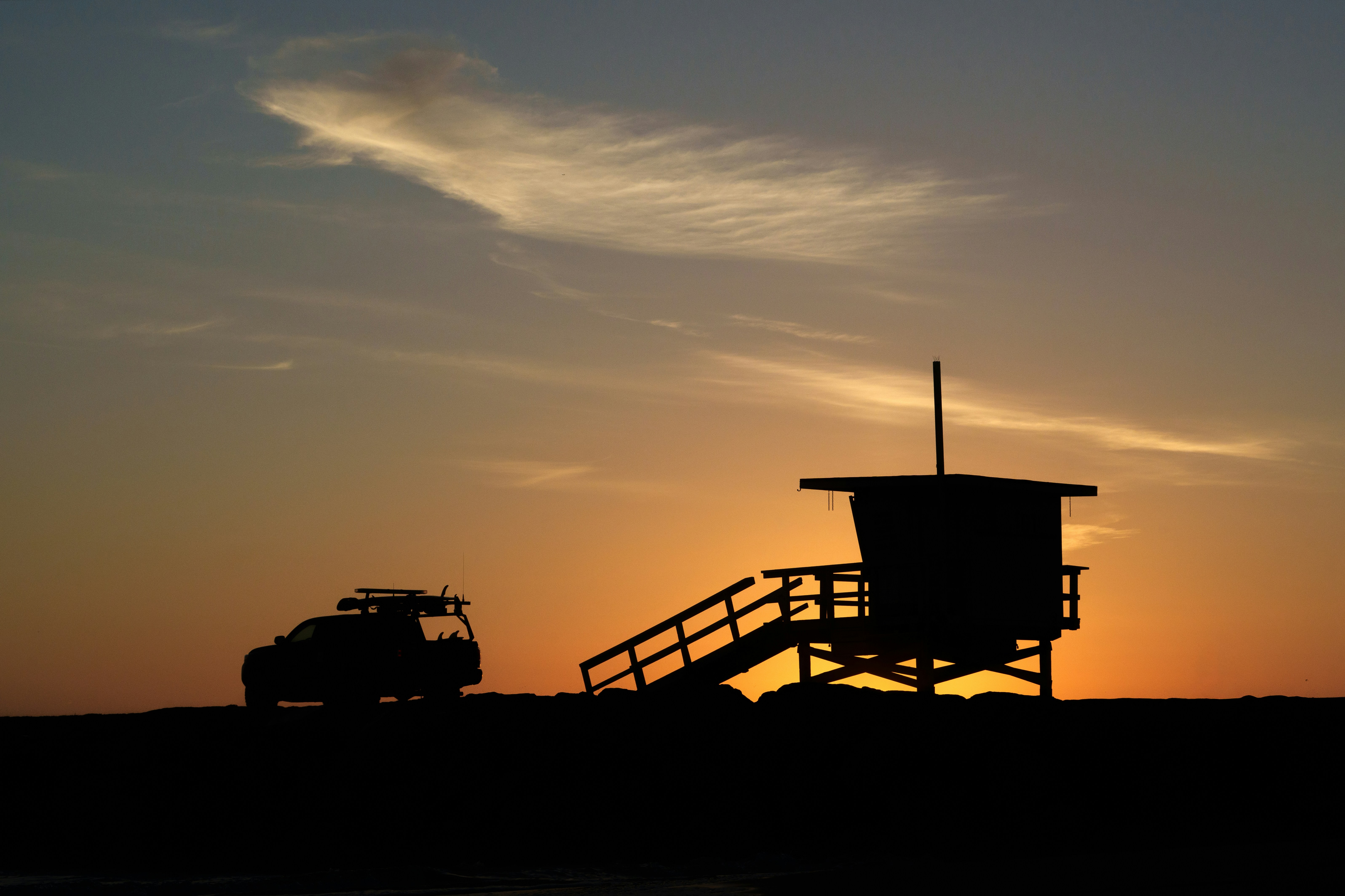 Silhouette at Dusk: A Lifeguard Platform Watches the Quiet Shore