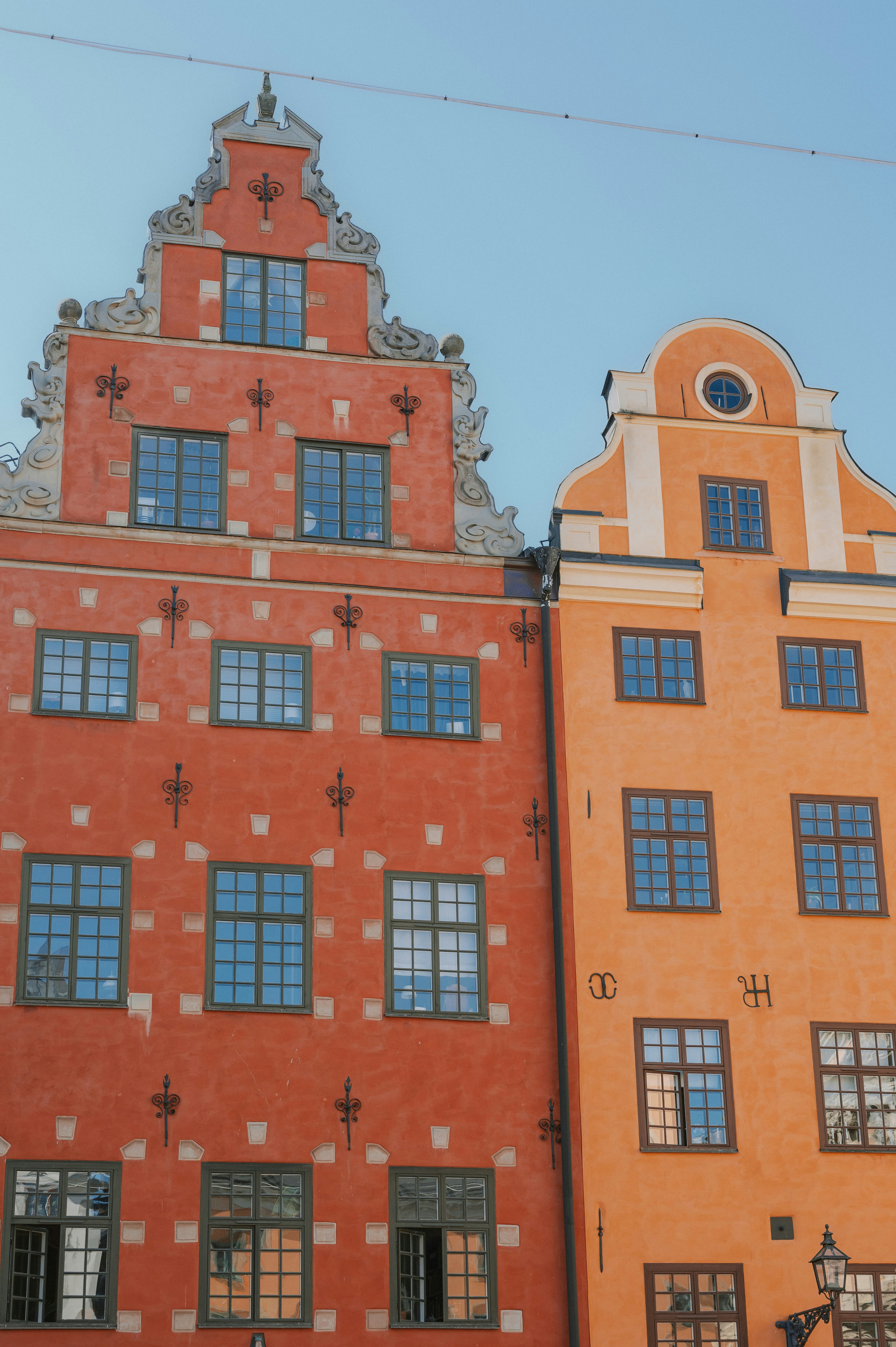 Twin Facades: A Splash of Coral and Apricot in a European Street