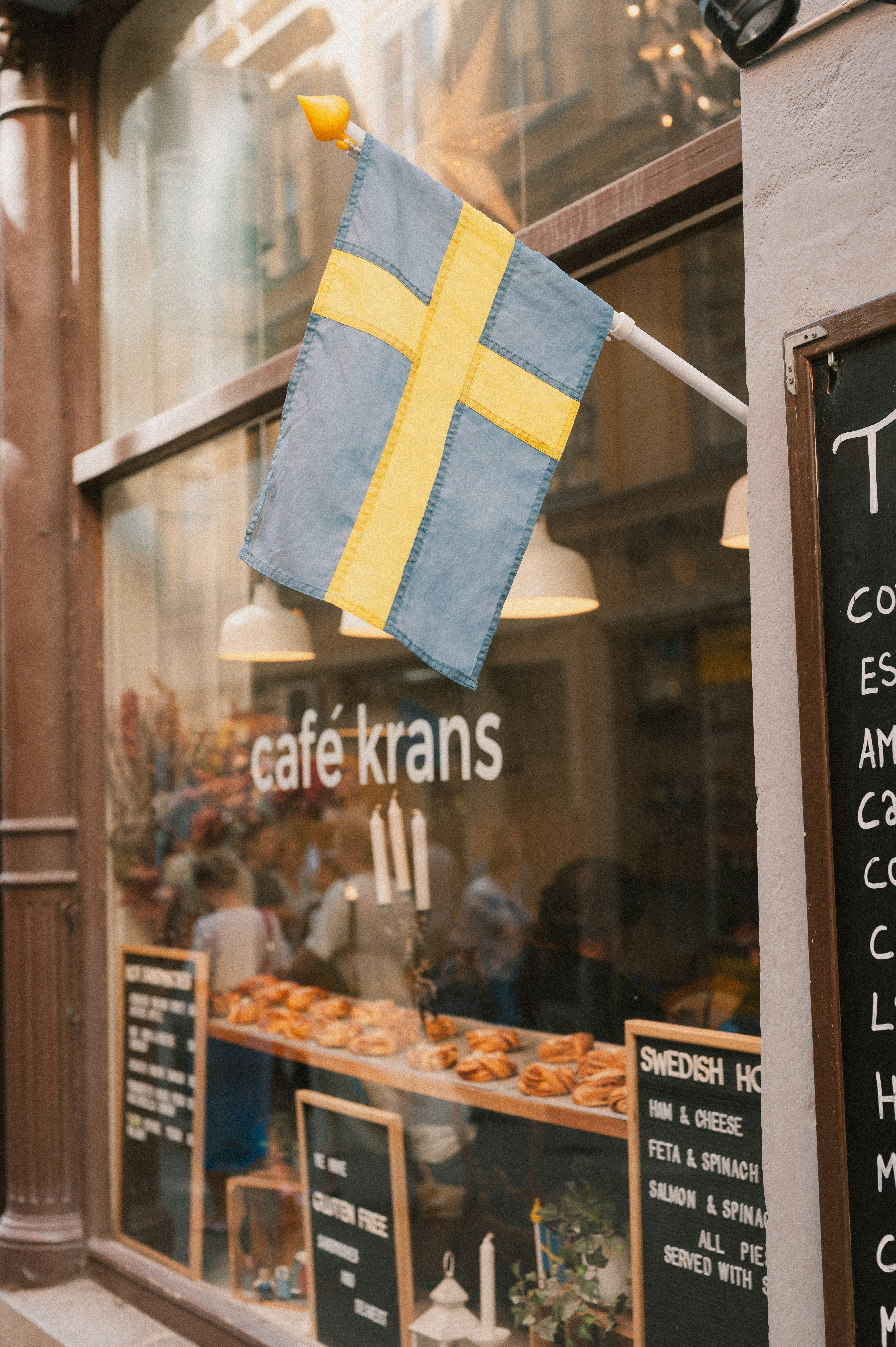 Flag in aCafe Window: Swedish Flag Framed by Pastry Display