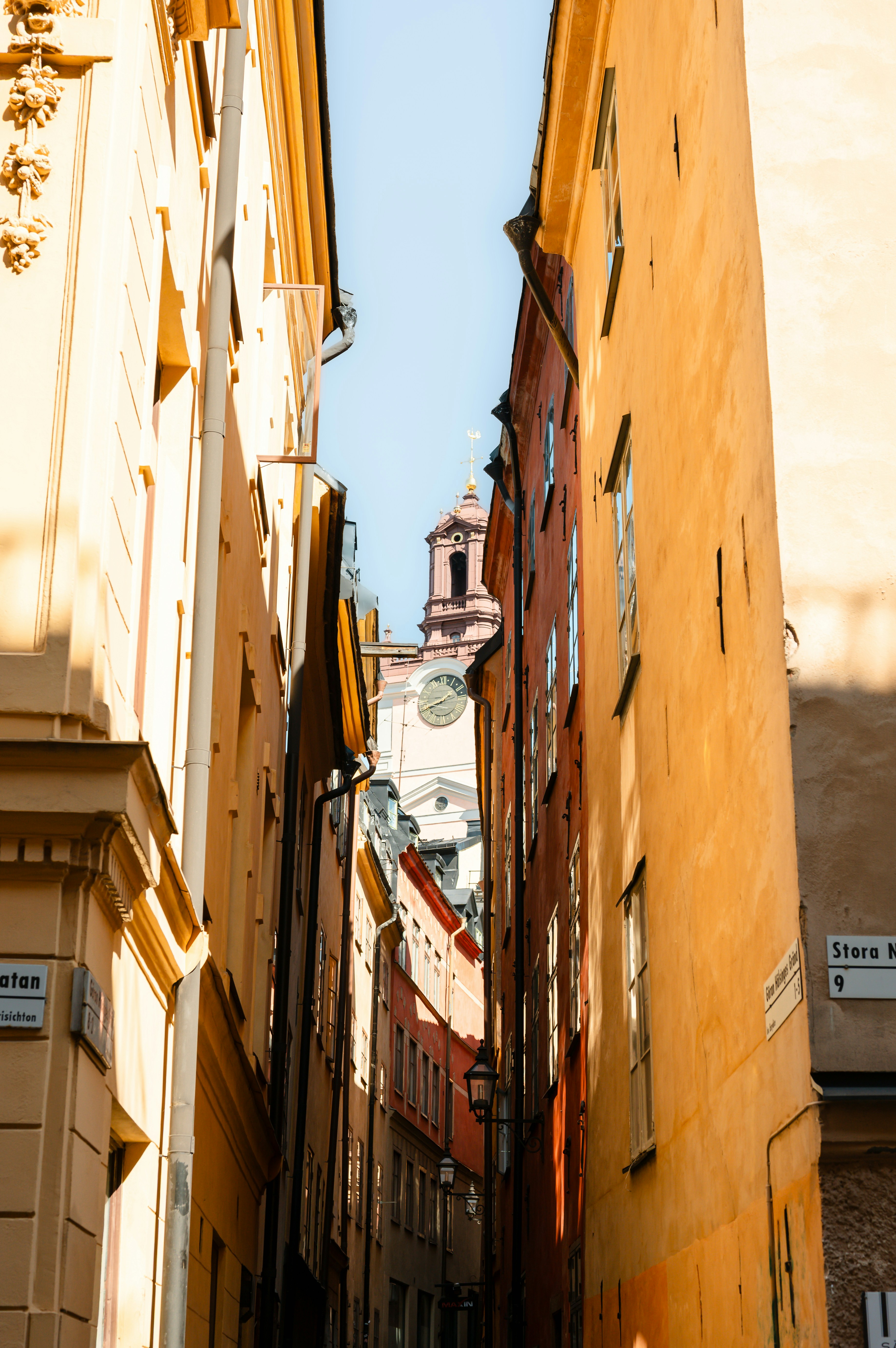 Narrow European Street Reaches Skyward Toward a Clock Tower