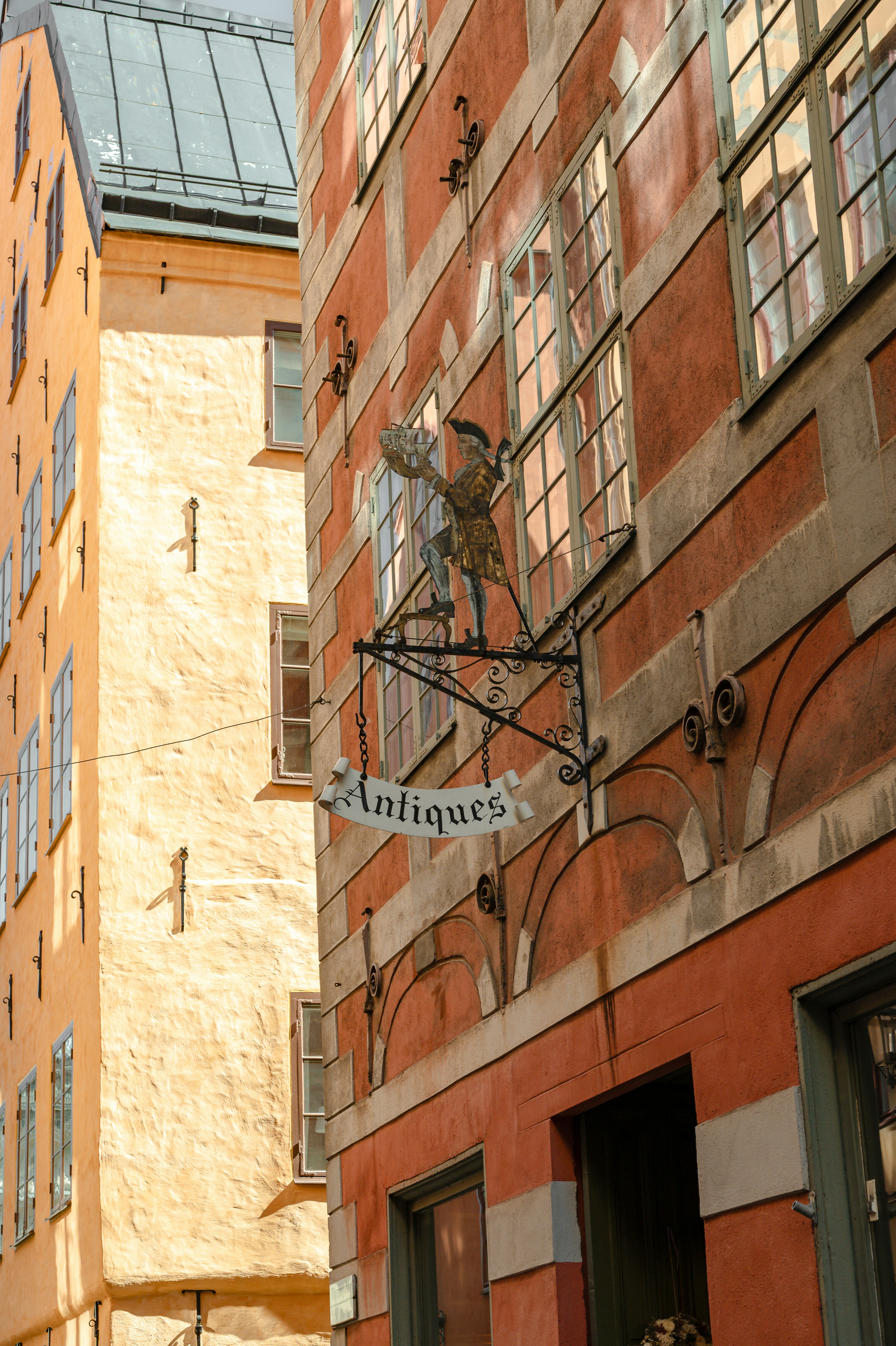 Antique Sign Adorned Facade: A Narrow Street in Warm Light