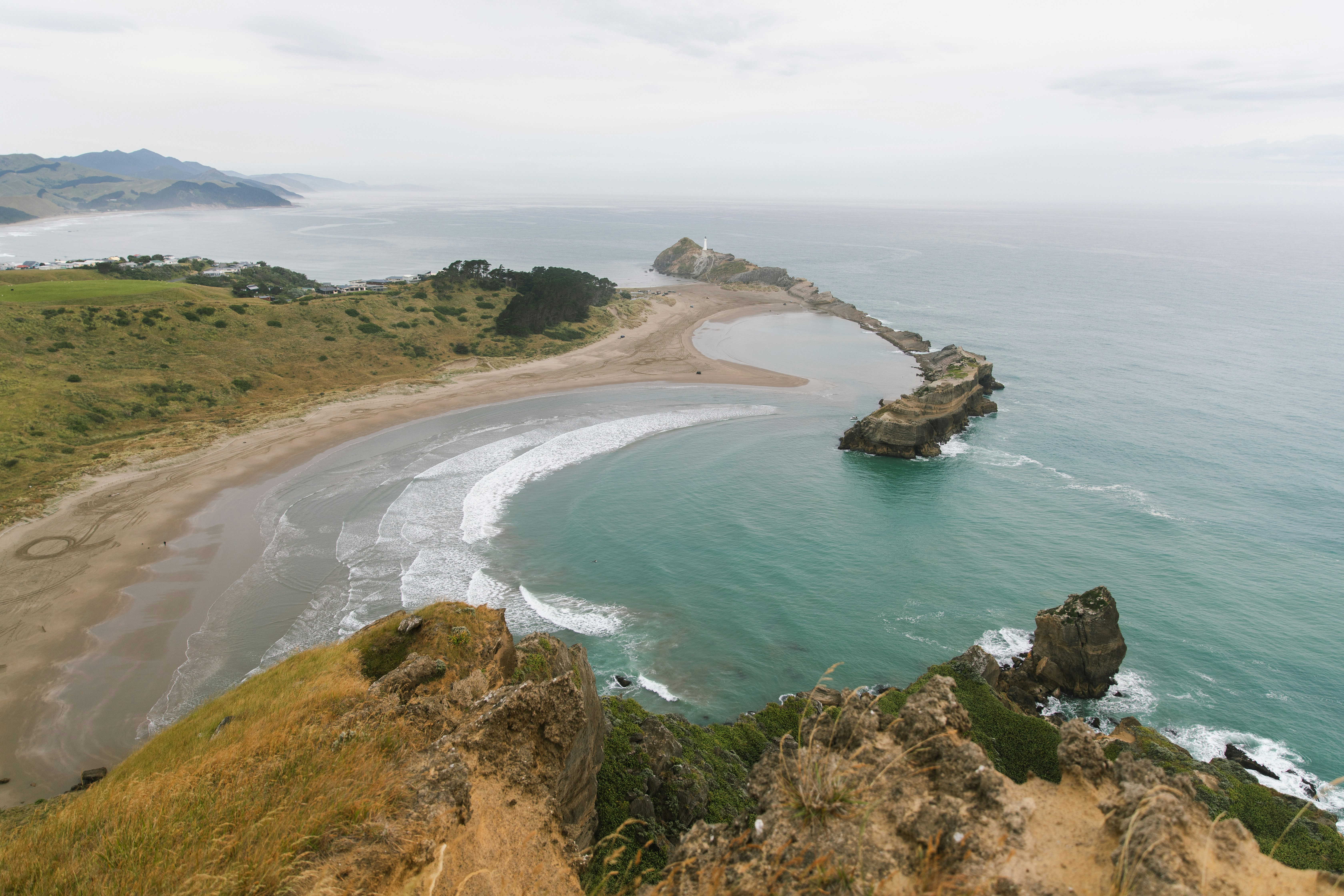 Promontory Overlook: Crescent Cove Surrounded by Cliff and Sea