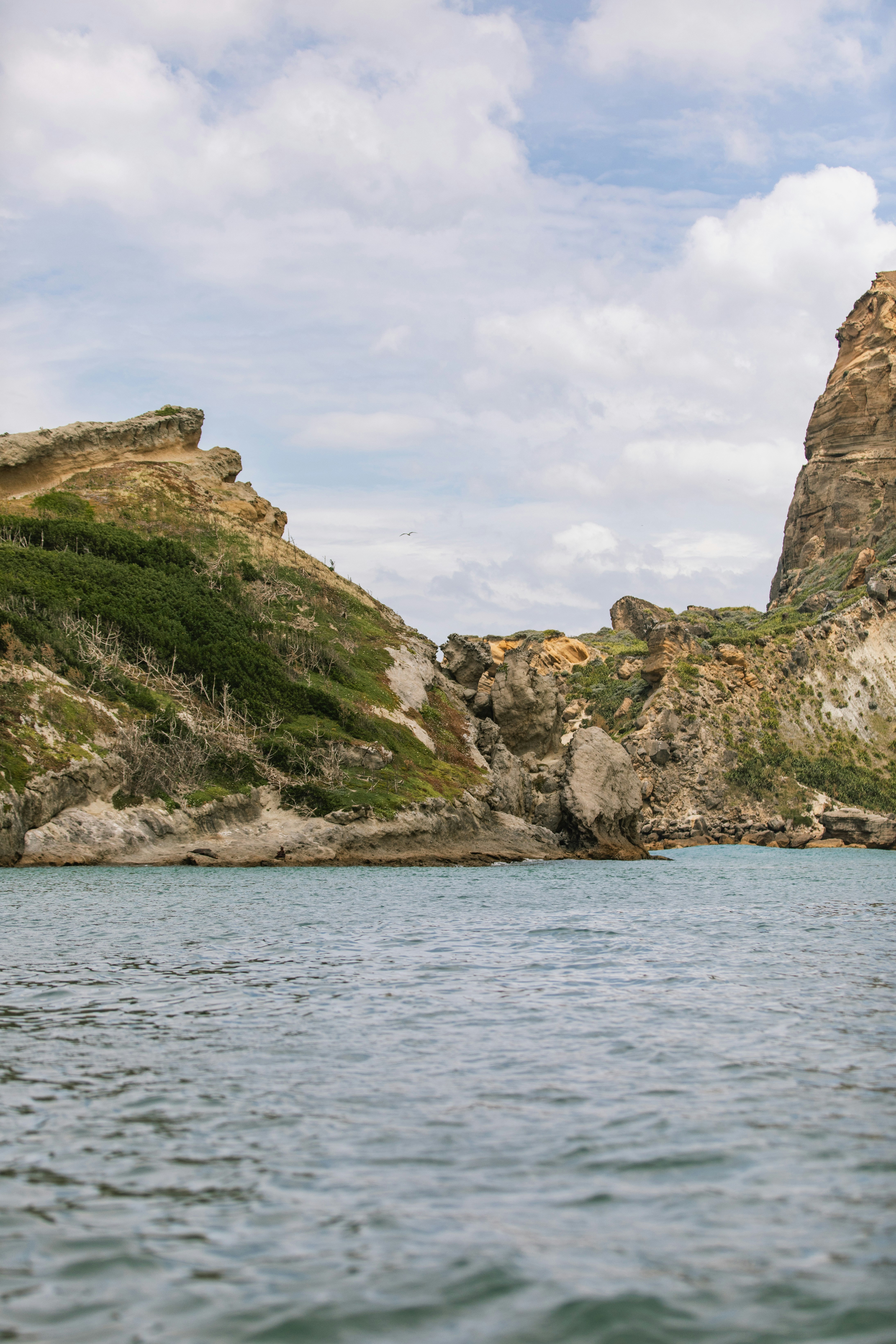 Coastal Cliffline at Sea Level: Sunlit Rock Faces and Gentle Waves