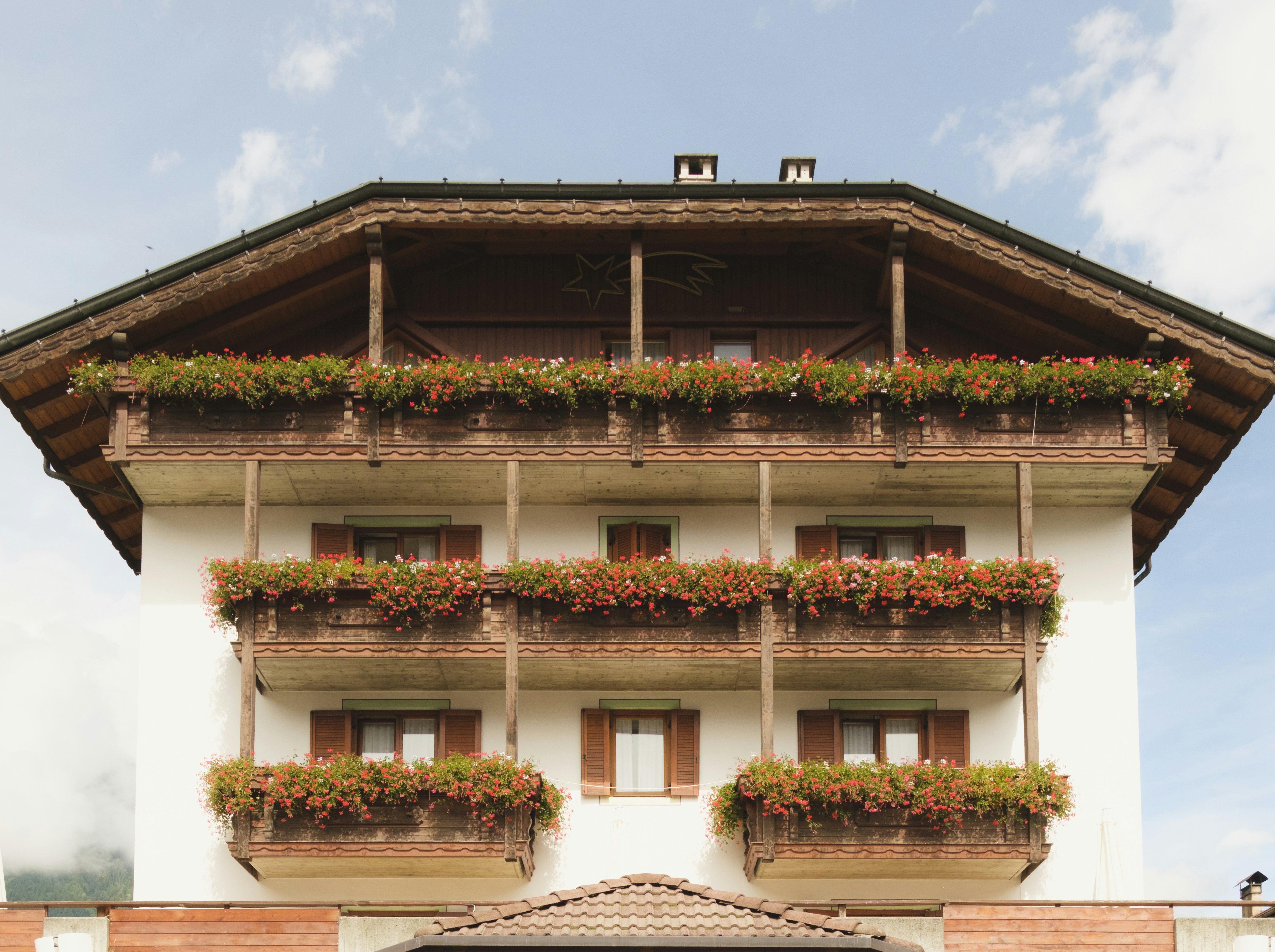 Balconied Chalet Bloom: Alpine Flora Framing a Three-Story Façade
