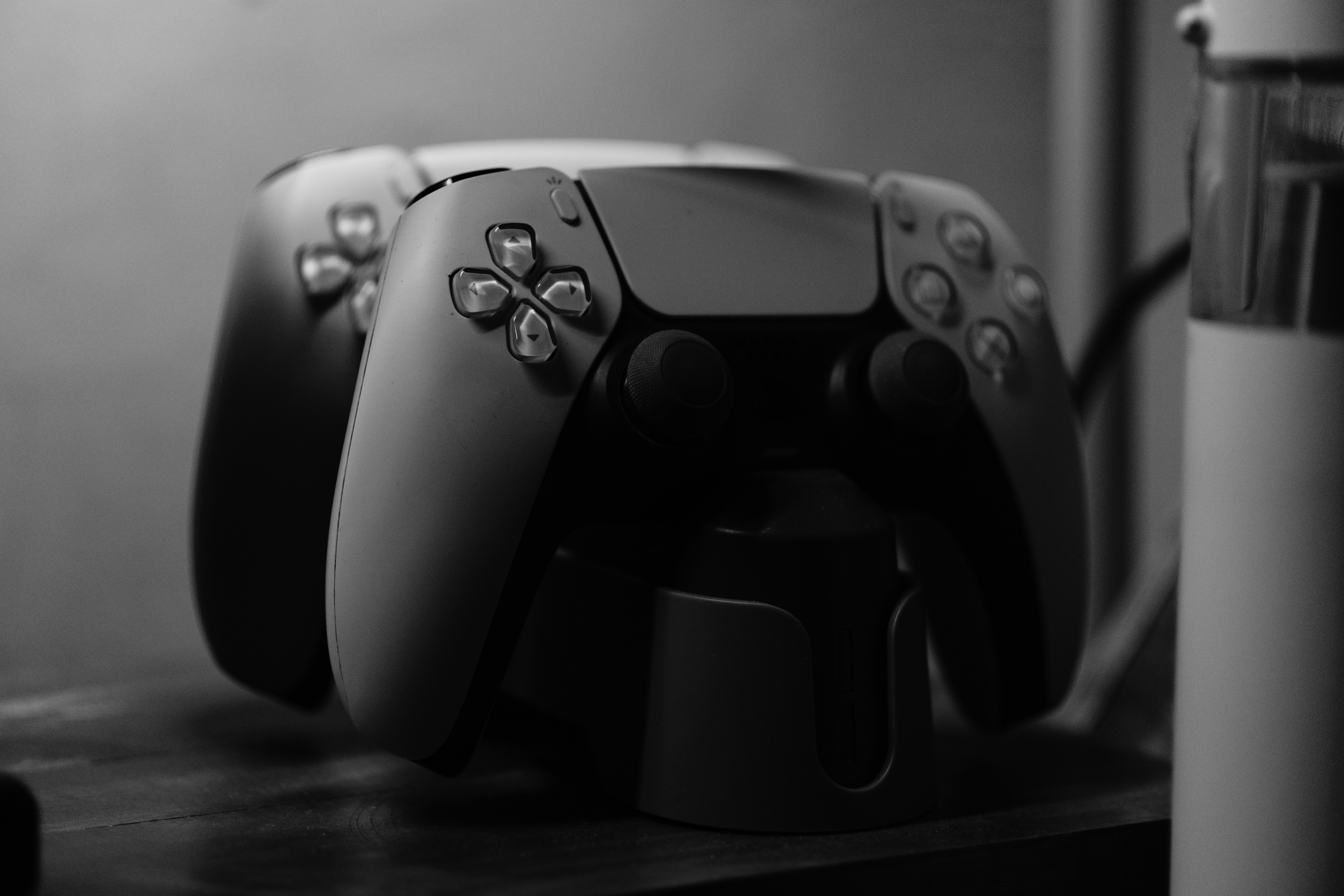 Two game controllers on a charging dock in a black and white photograph