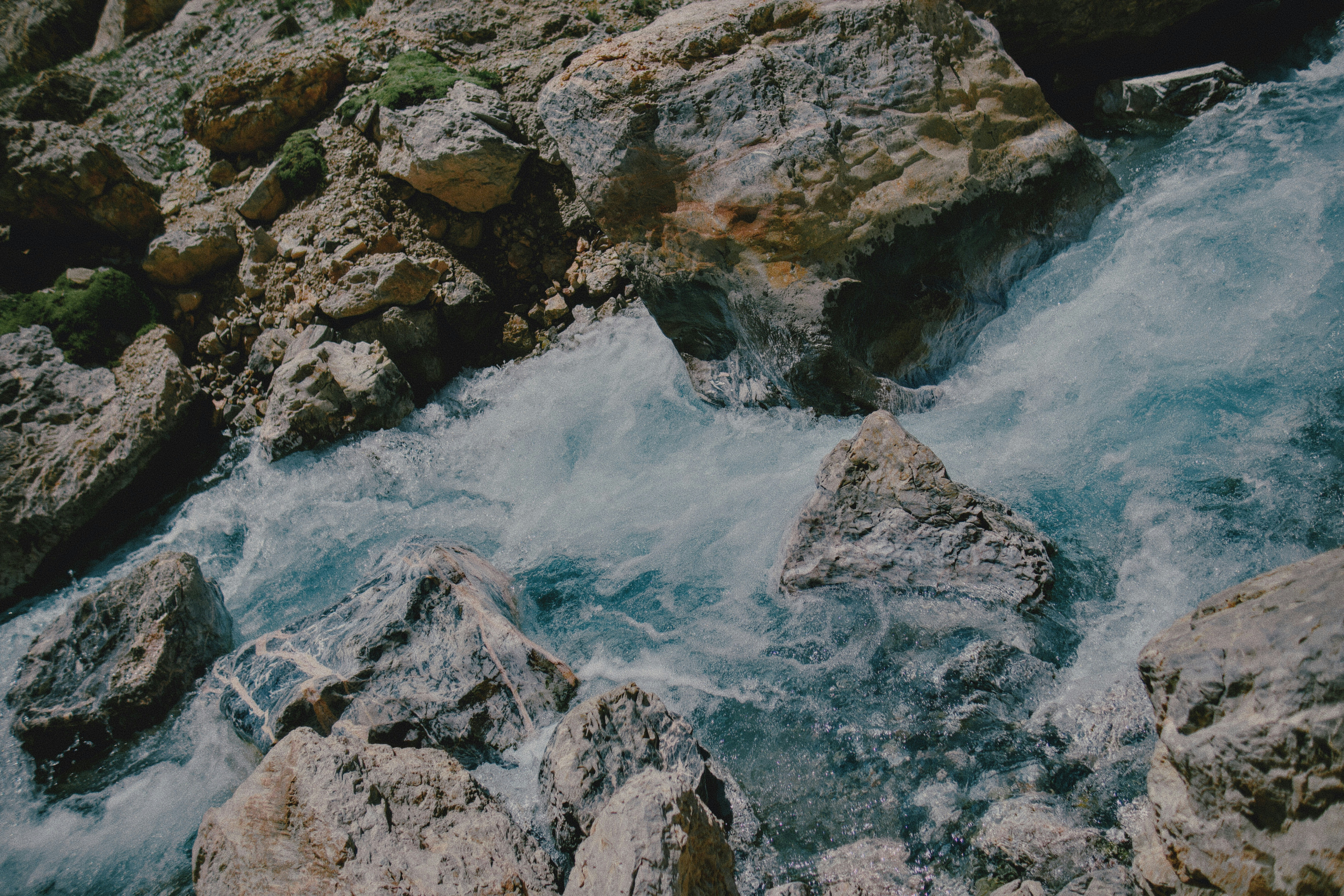 Rugged Cascade: Turquoise Currents Between Weathered Stones