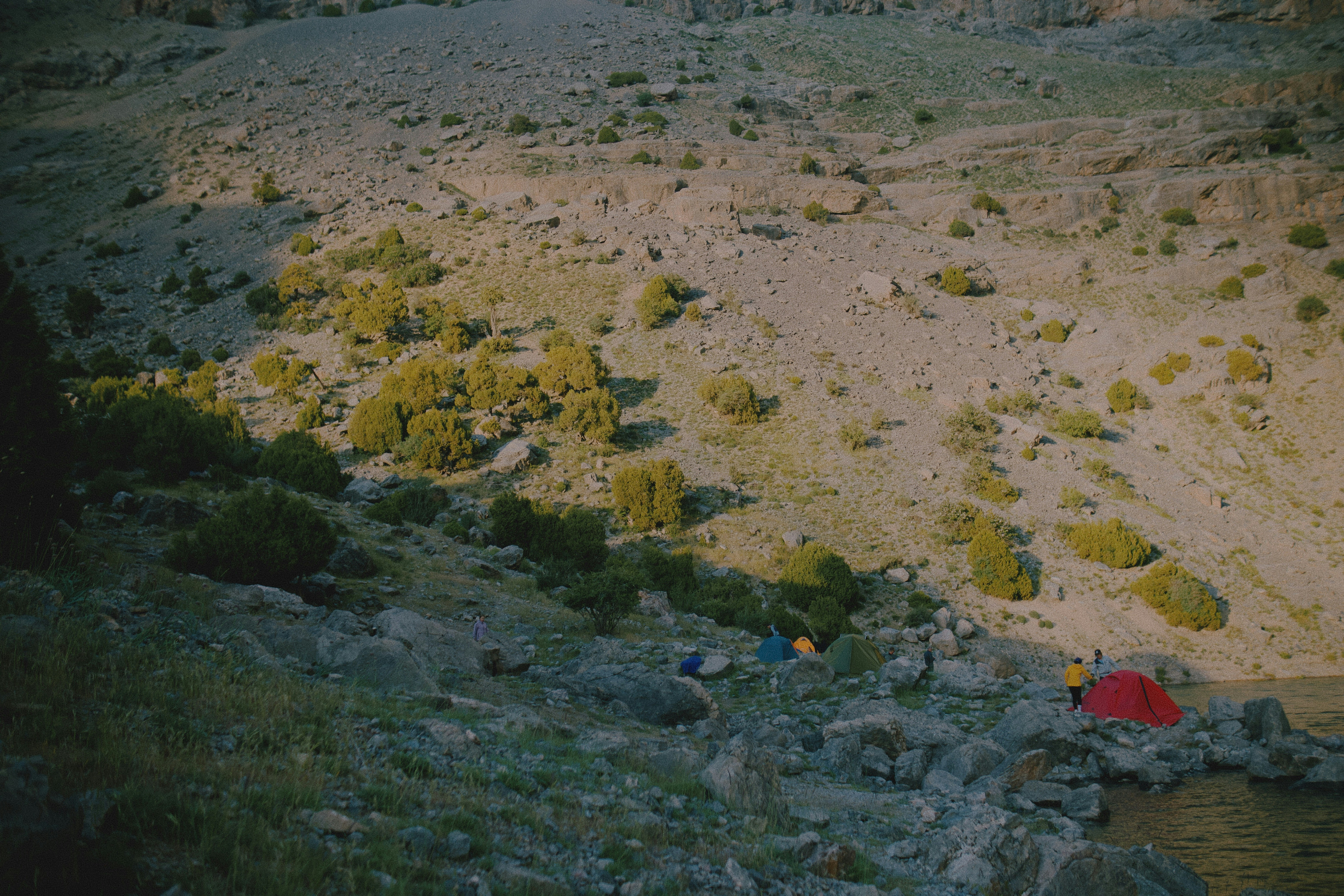 Deserted shoreline camp under rocky slopes