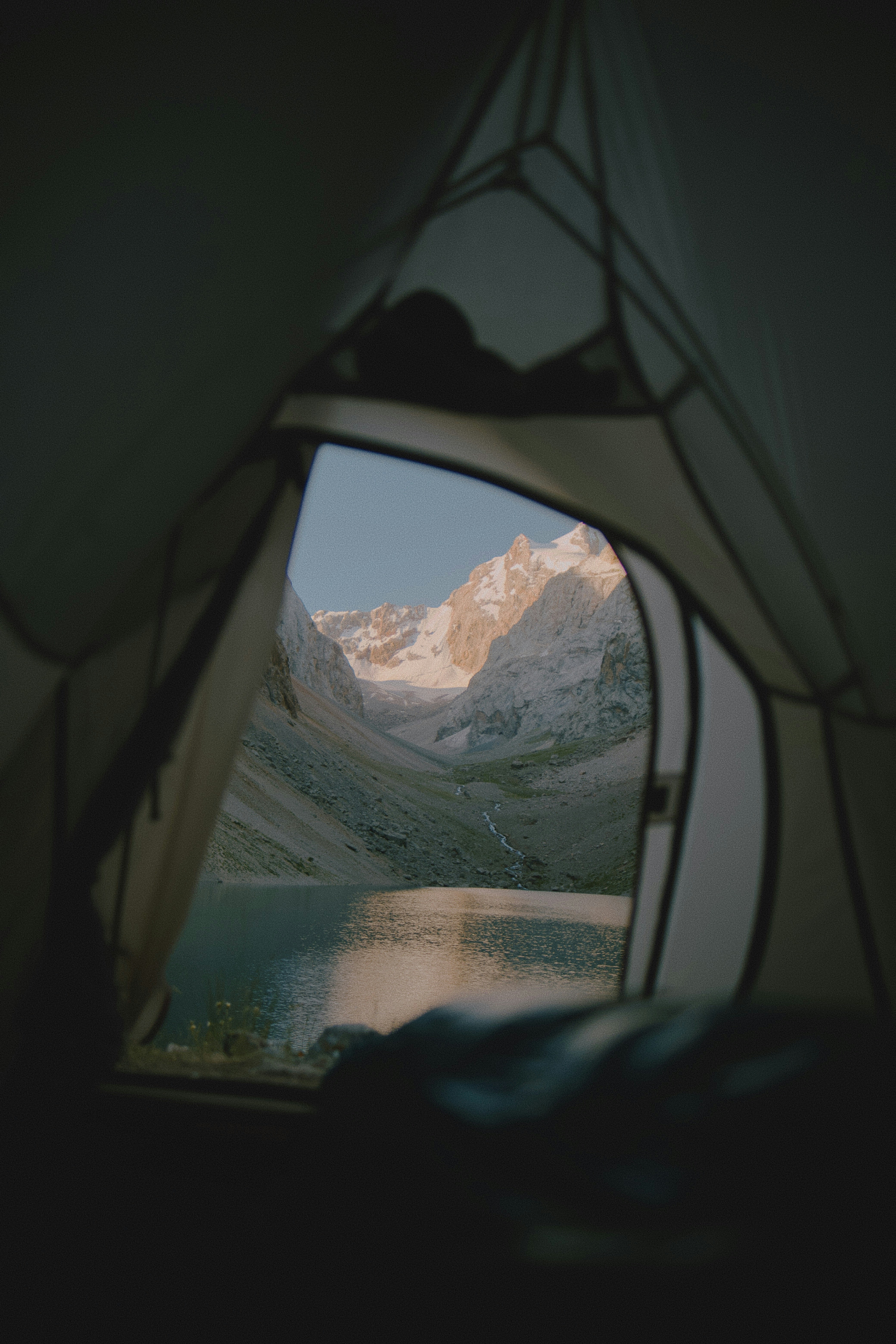 Tent Portal to Alpine Mirror: Snow-Spired Valley Framed by the Tent Window