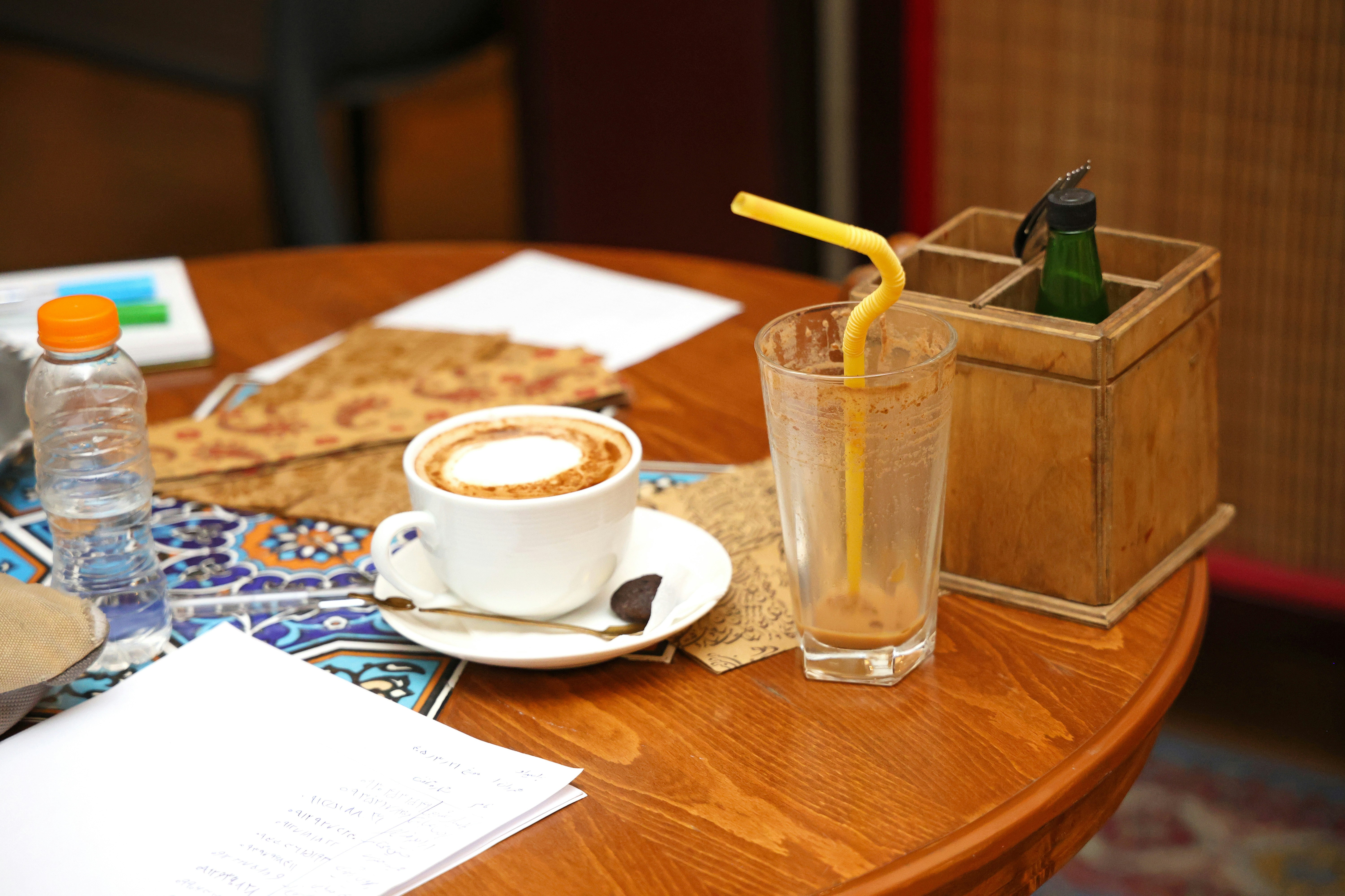 A Quiet Café Table: Latte, Lemonade, and a Green Bottle