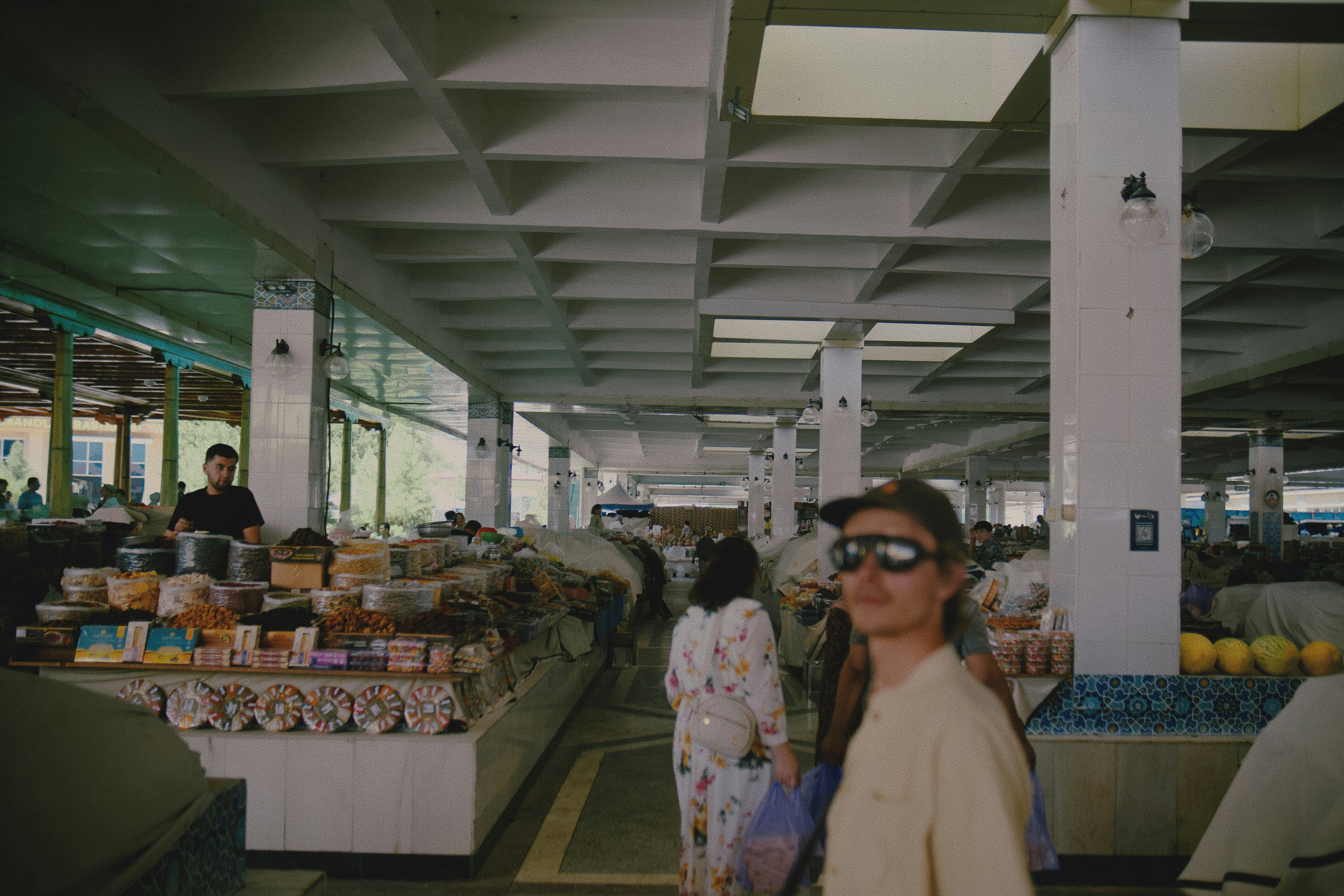 Market Corridor: A Haze of Shoppers and Vendors Under Concrete Beams