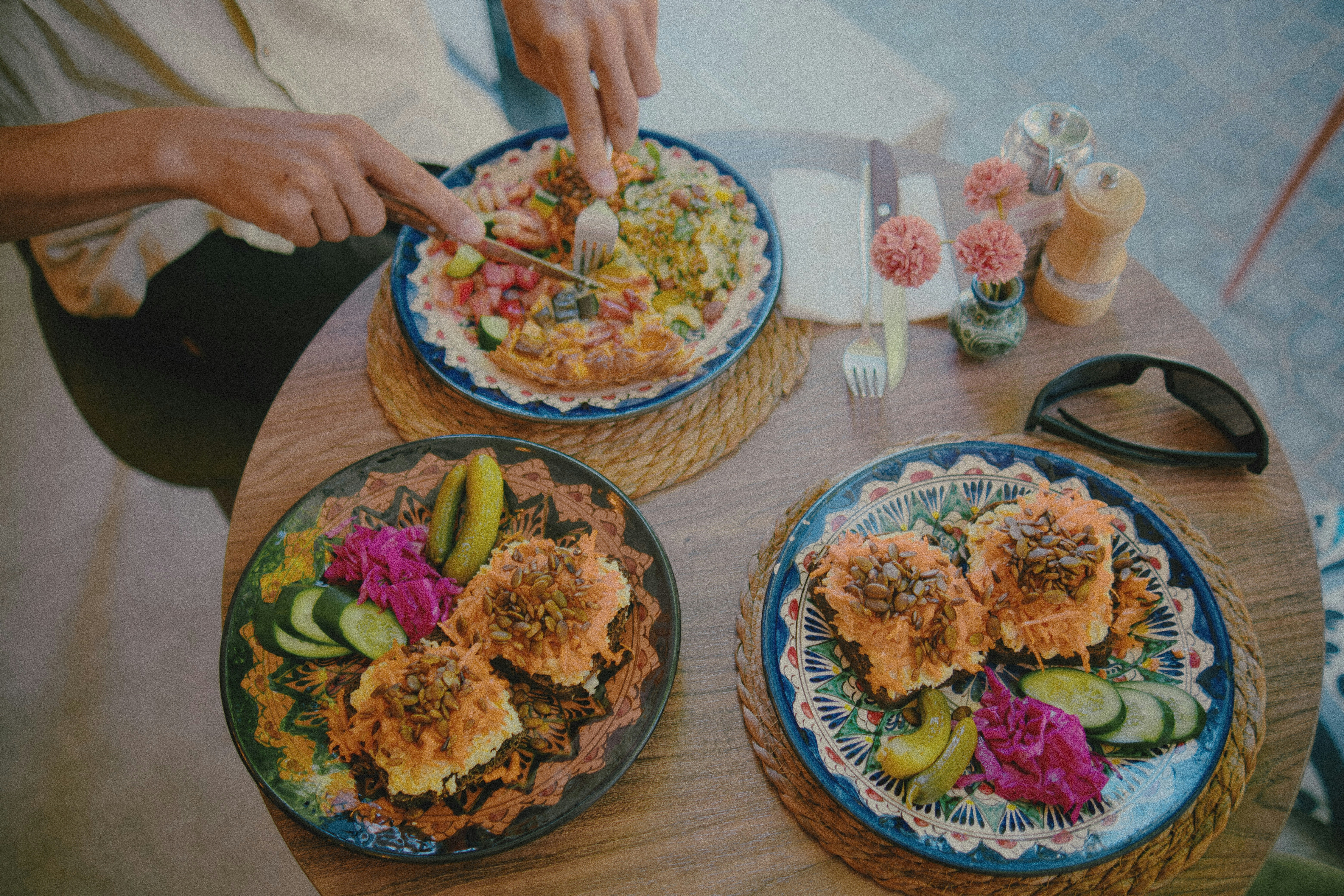 Tabletop Feast: Fried Dishes and Fresh Veggies Shared Around a Sunny Table