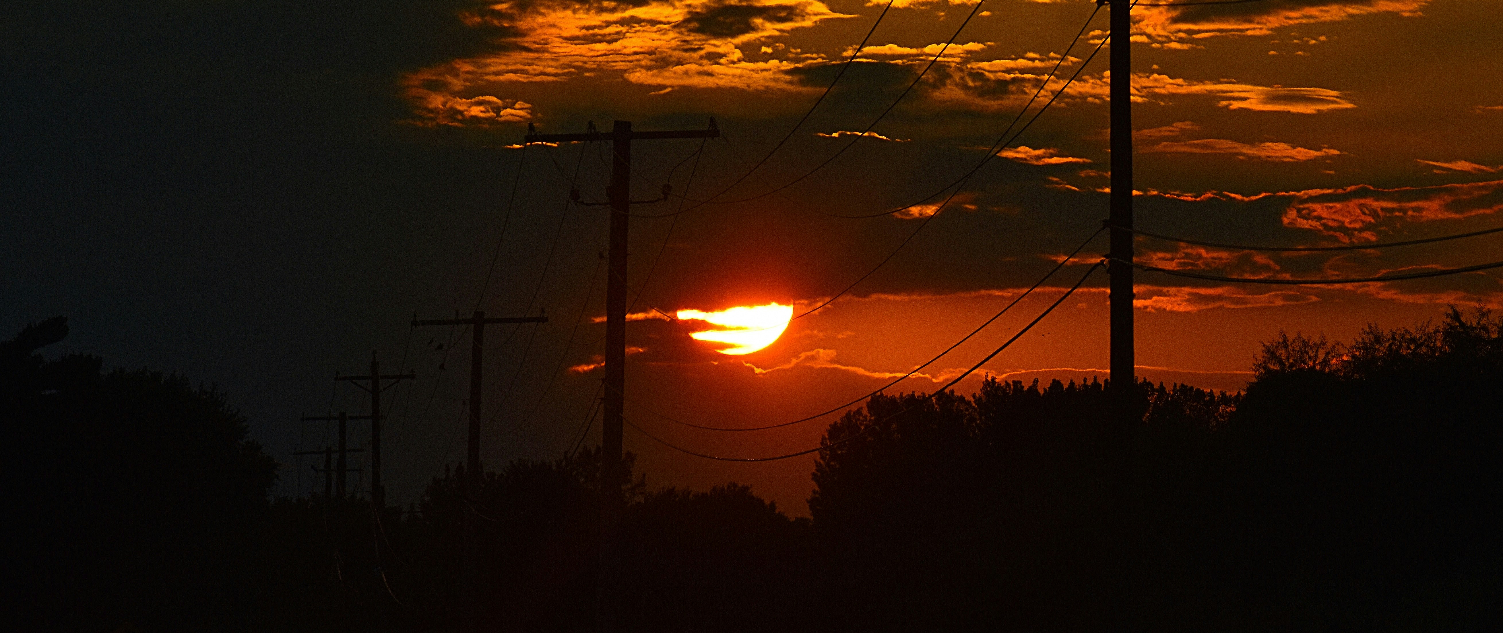 Sun Dune: Silhouetted Power Lines at Dusk