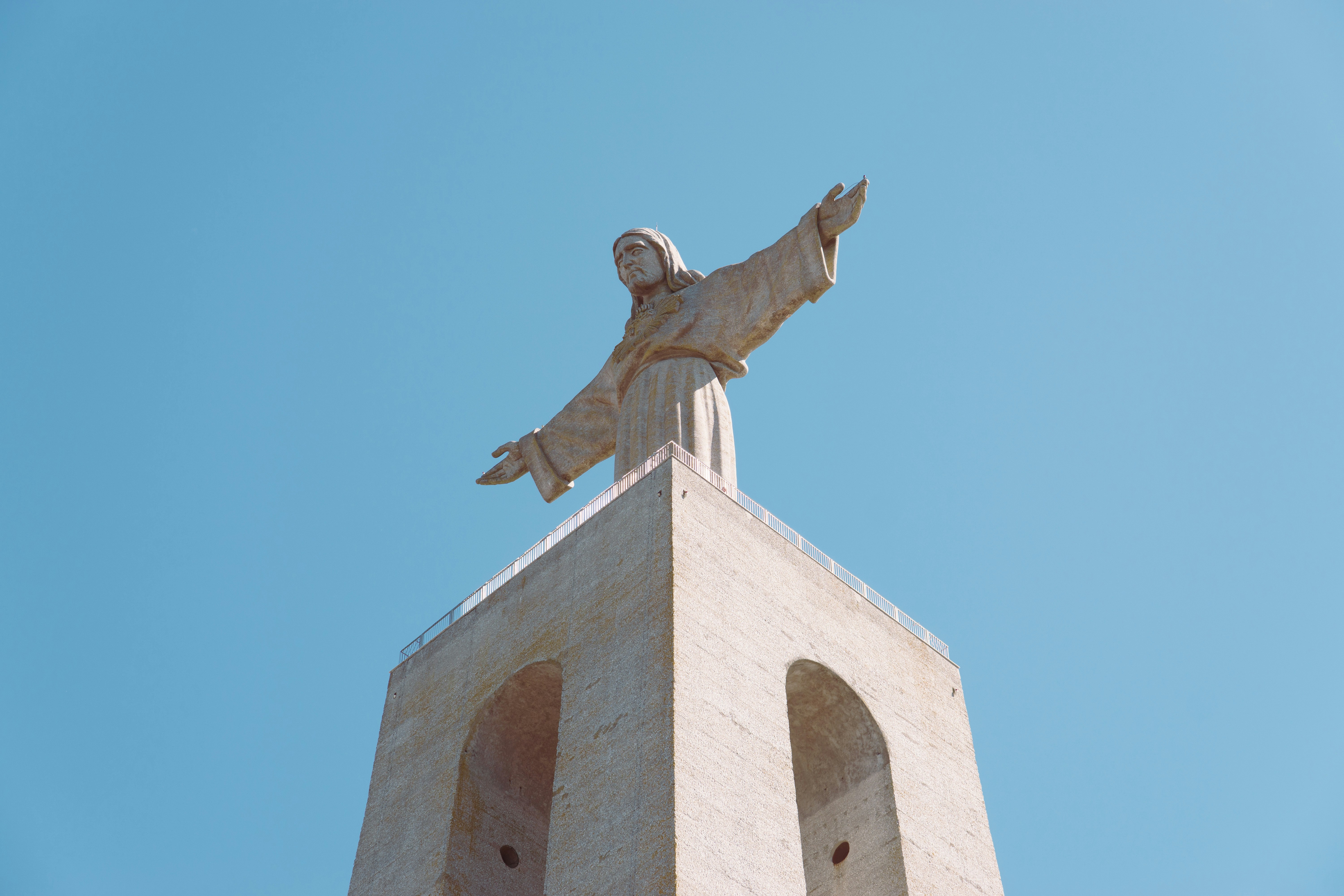 Statue of Hope Crowned on a Stone Spire Under a Clear Sky