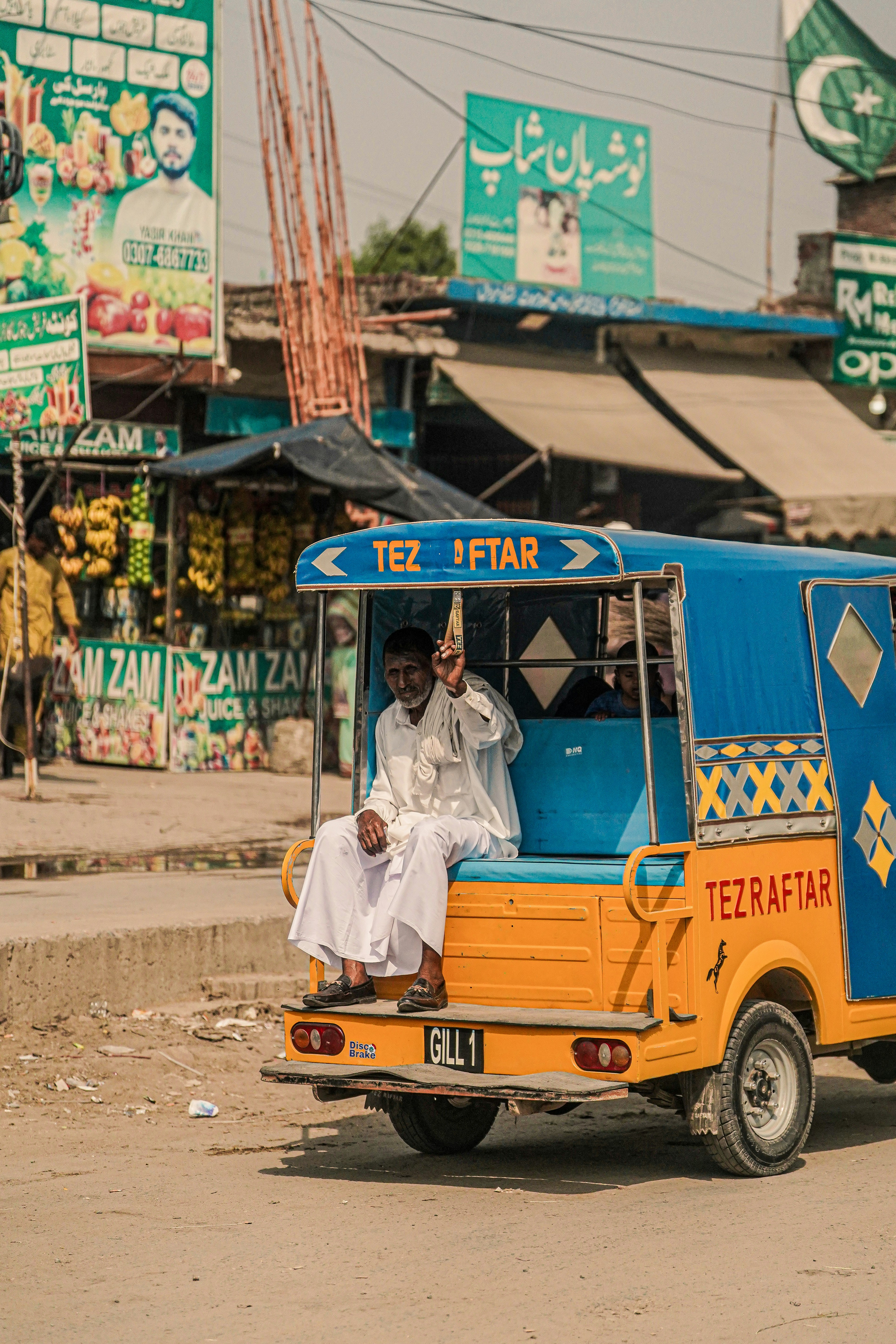 Rickshaw Ride: A Sunlit Pause in a Busy Pakistani Street