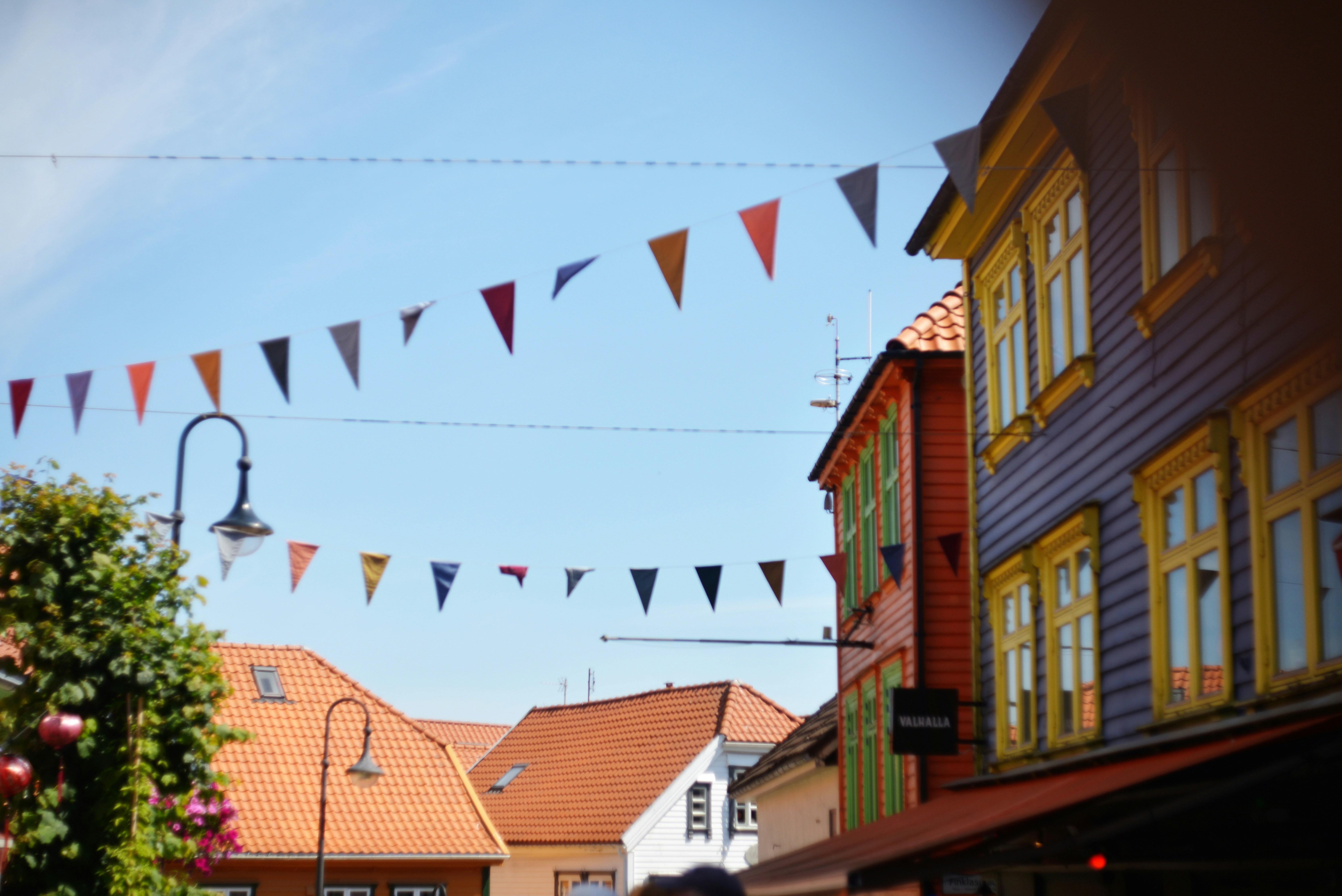 Colorful Street Flags Overhead in Sunny Nordic Village