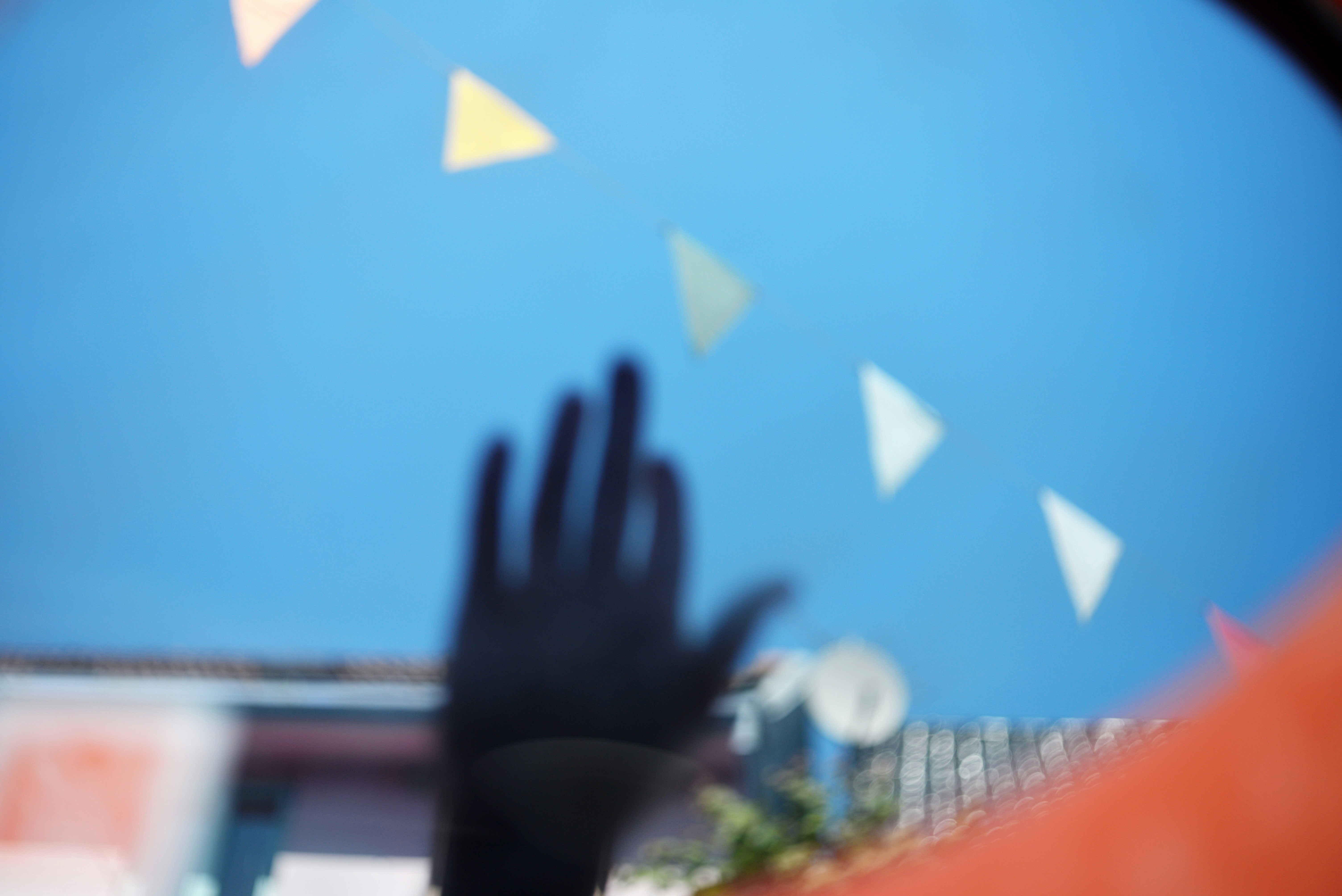 Blue Sky, Black Glove: A Faded Hand Reaching Toward the Void