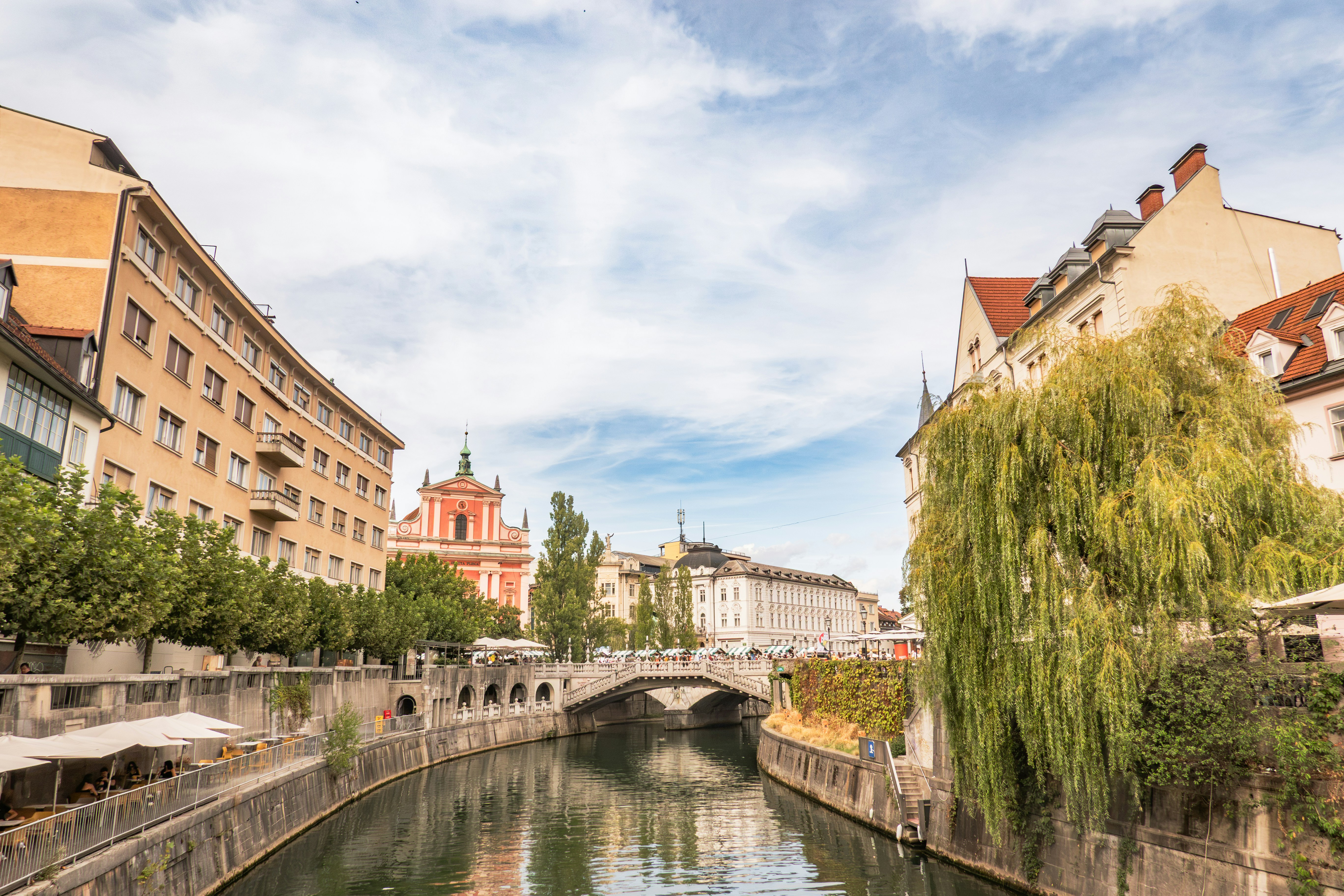 Canal Toward the City: Historic Bridge Framing in a Sunlit Riverside Village