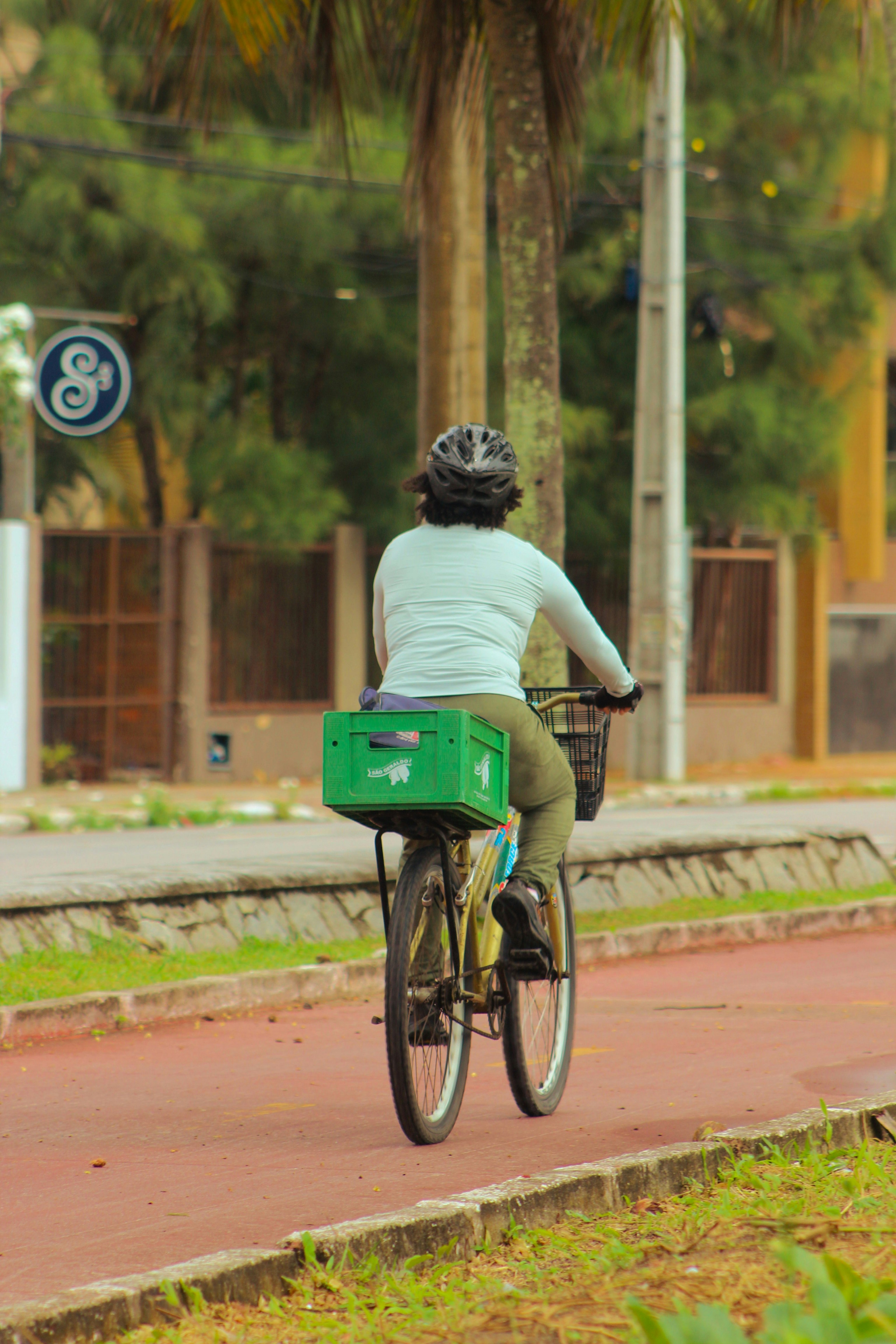 Cyclist with Green Cargo Box: Evening Ride on a Quiet Street