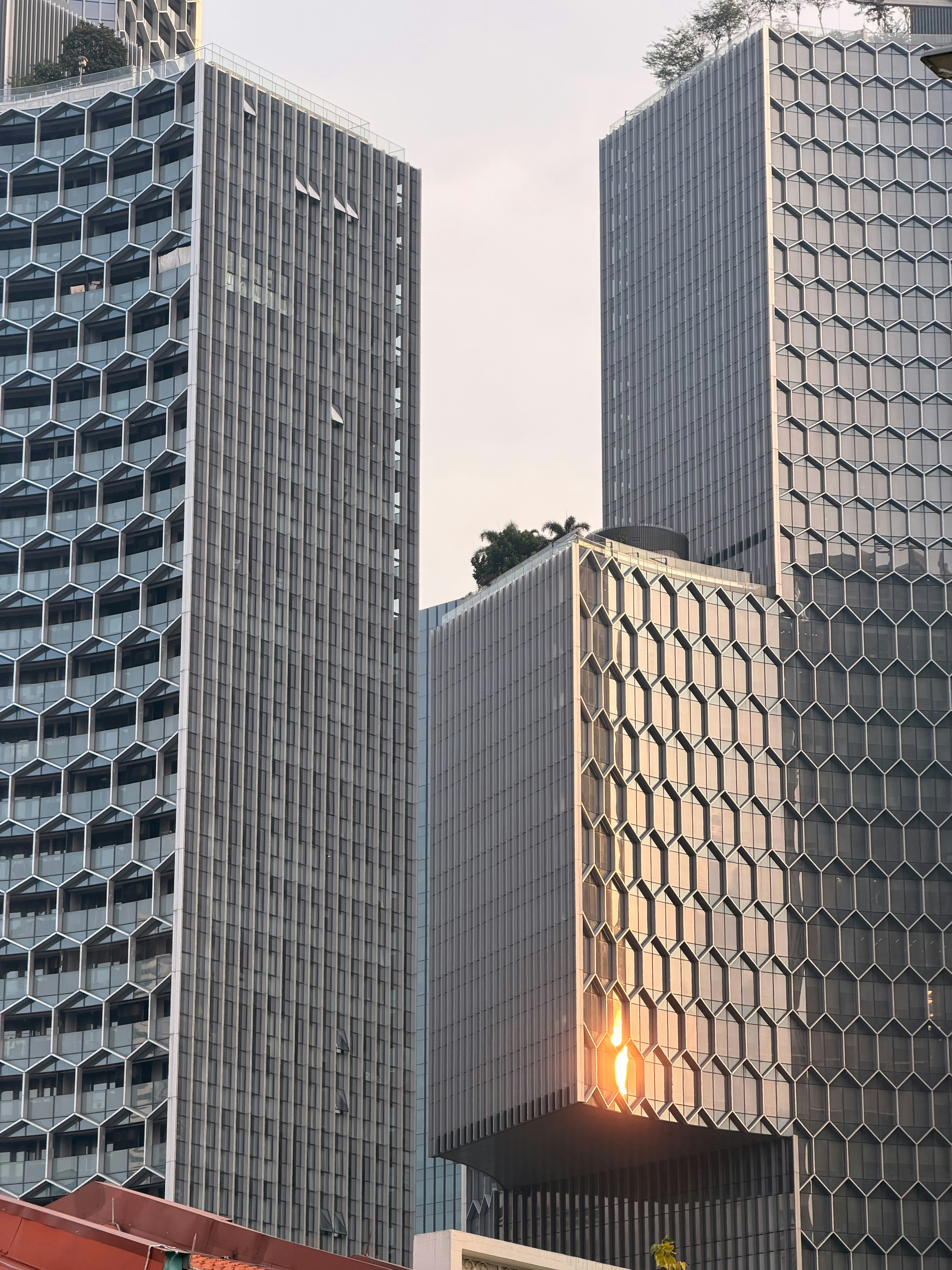 Hexagonal Facade Dusk: Towers Nestling a Glowing Cantilever