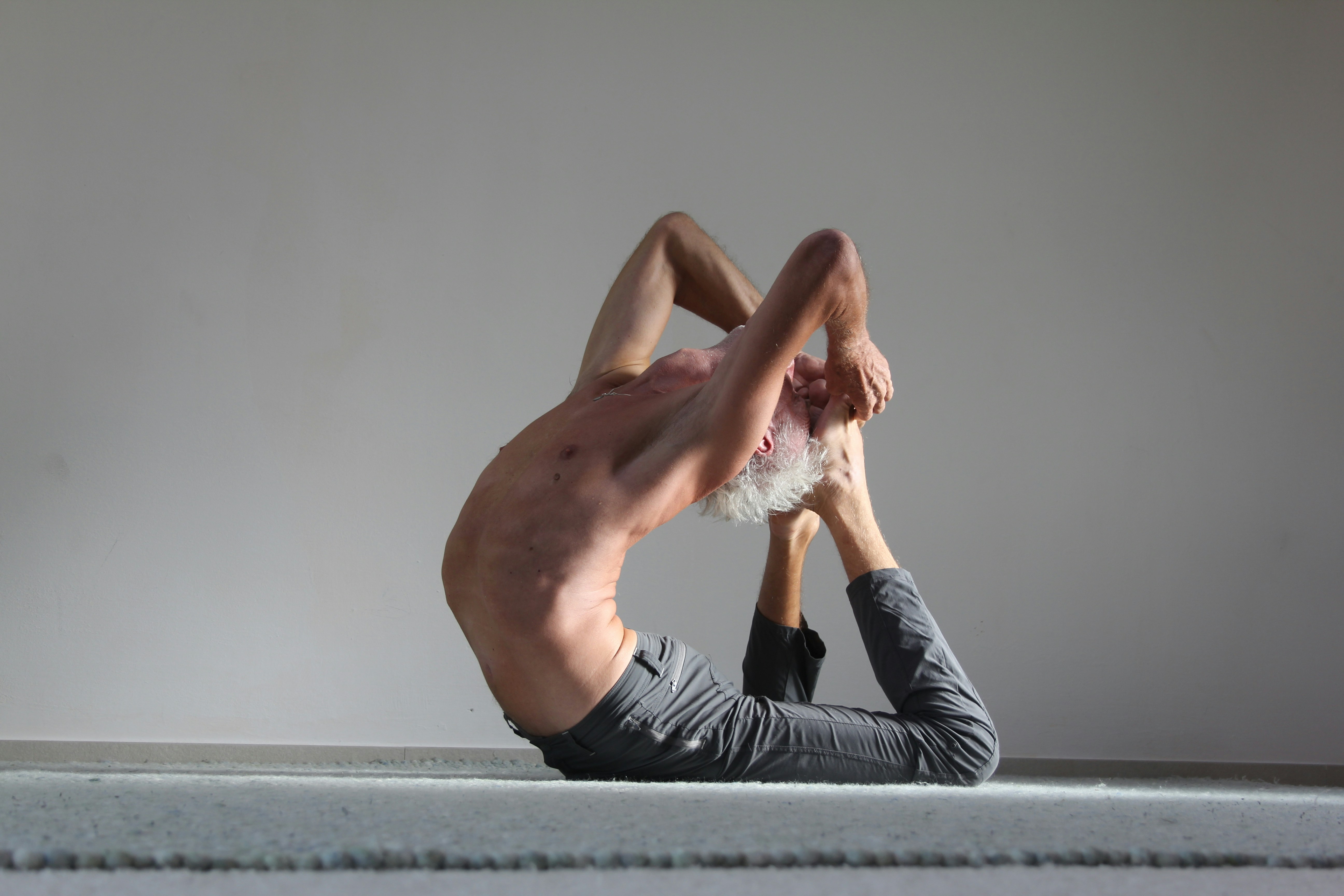 Entranced in the Inward Arch: a Yoga Pose Against a Quiet Wall