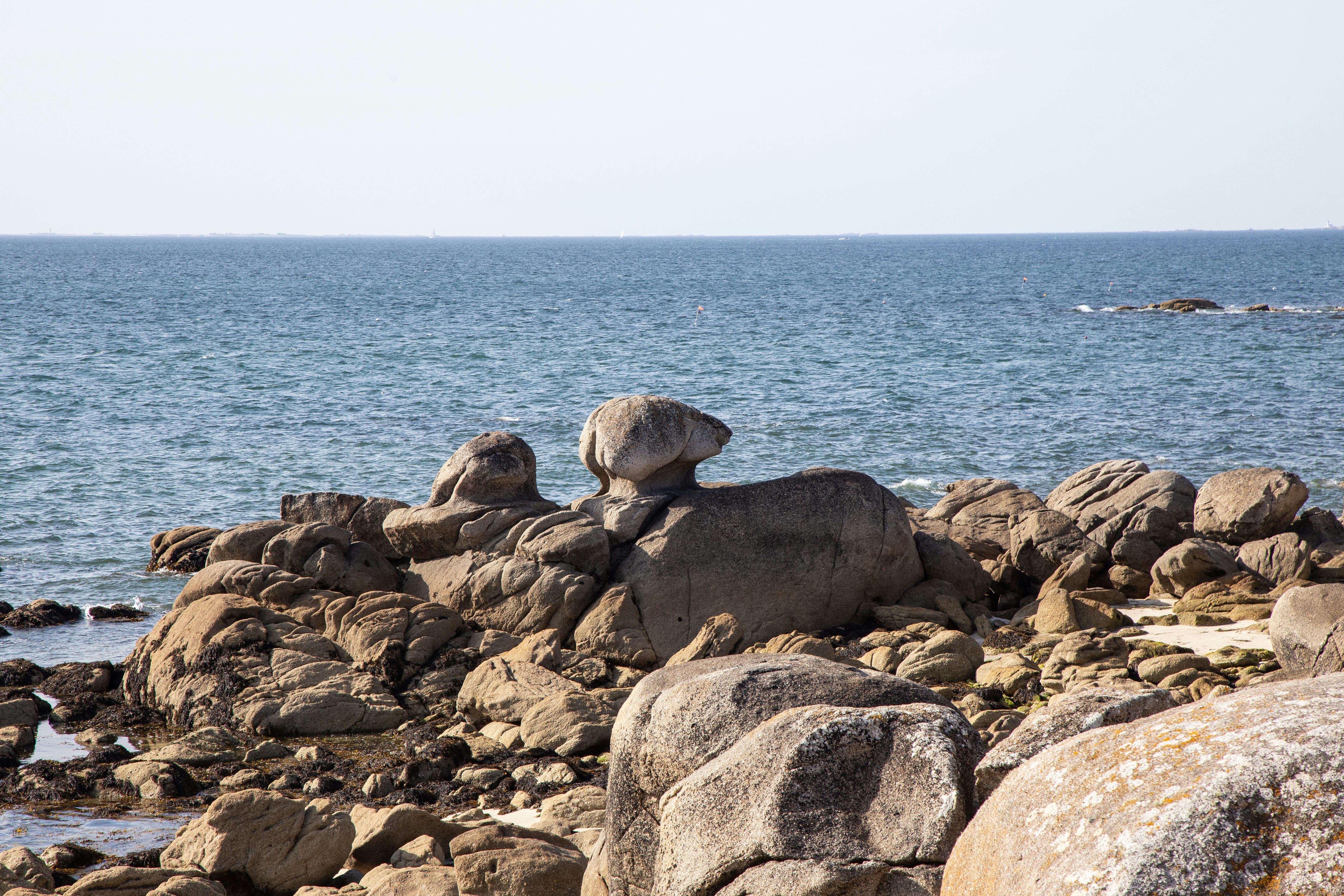 Rugged shoreline skyline: sunlit boulders meeting the sea