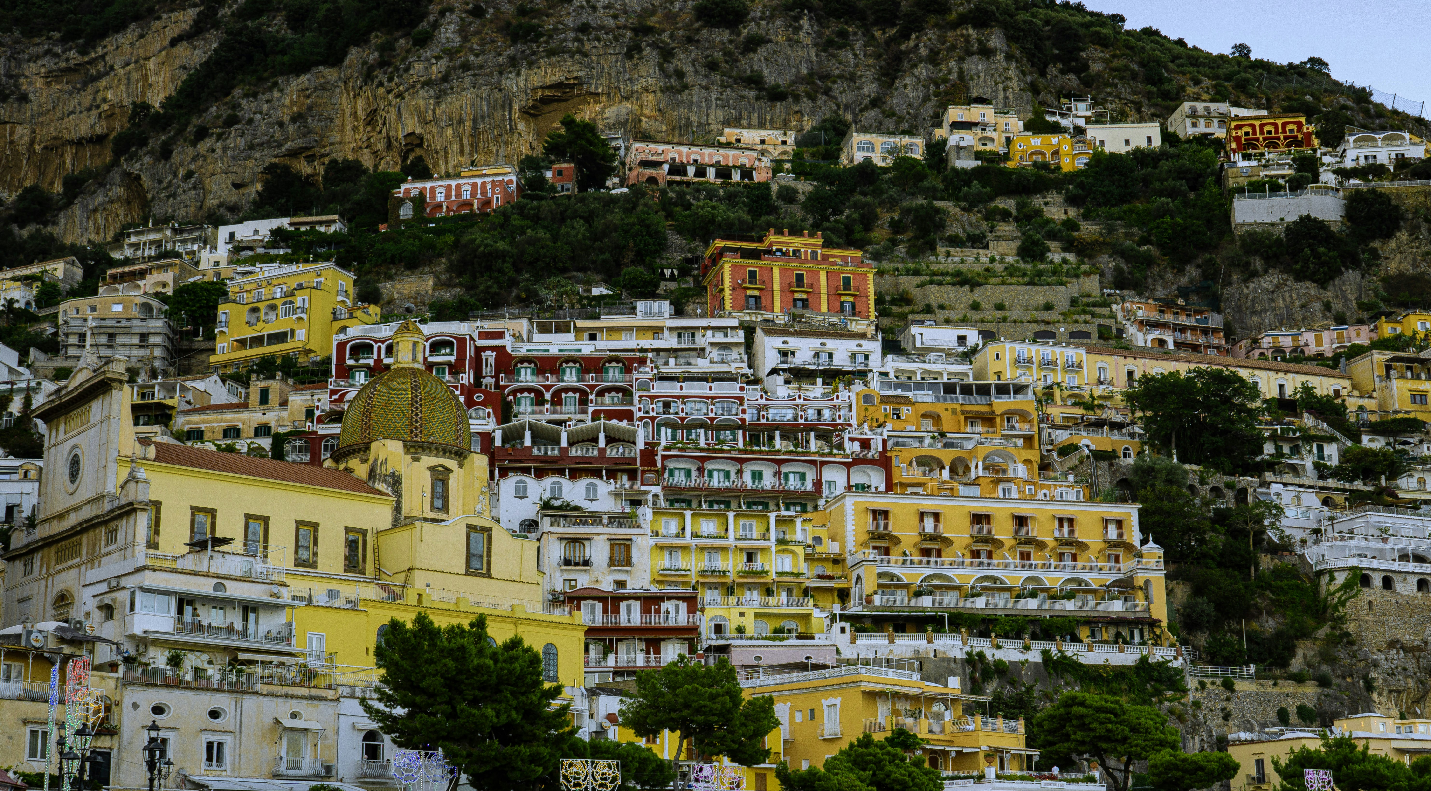 Sunlit Italian hillside: stacked pastel homes cascade into cliffside town