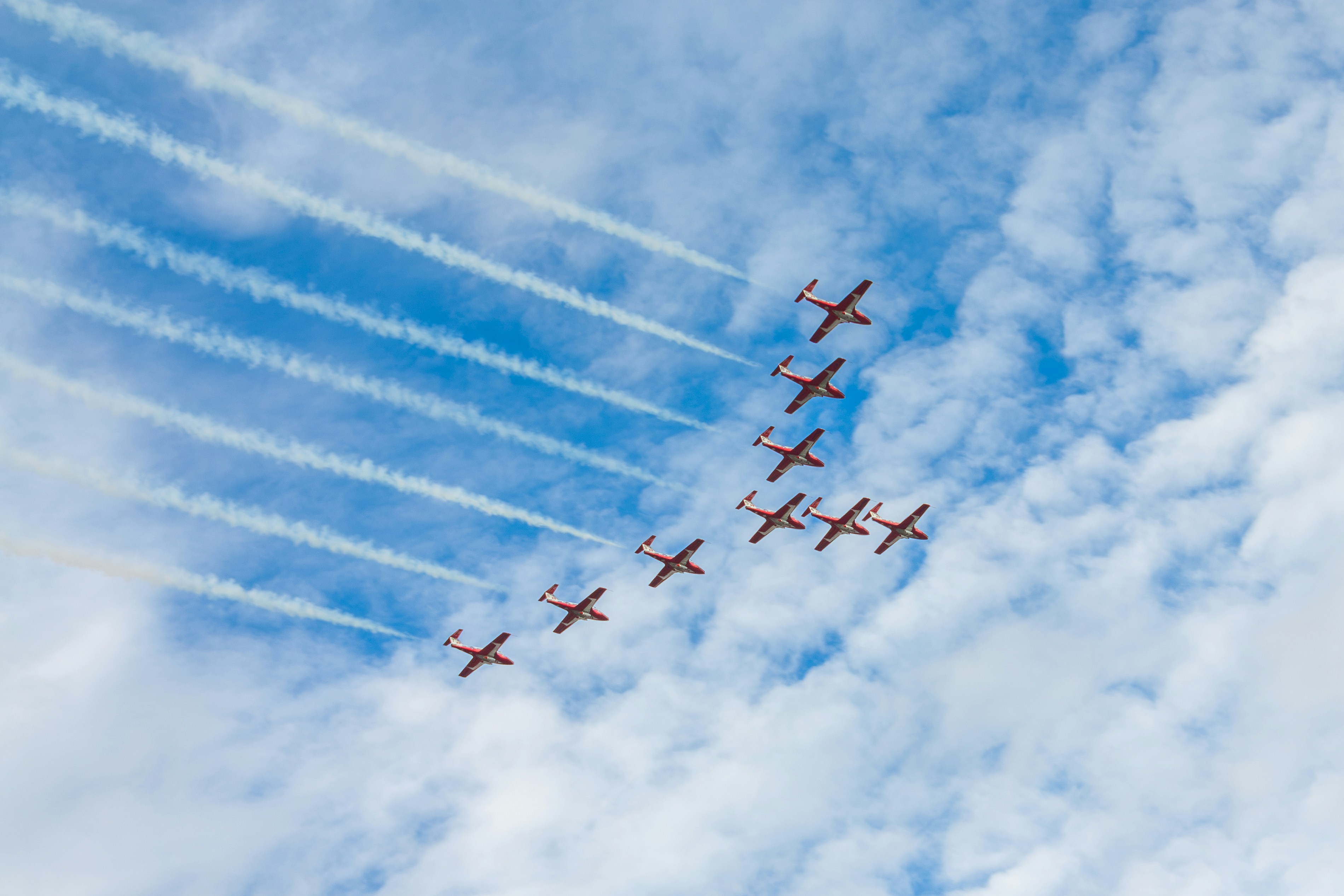 V-formation Skyprint: Jet Team Rains Contrails Across a Bright Sky